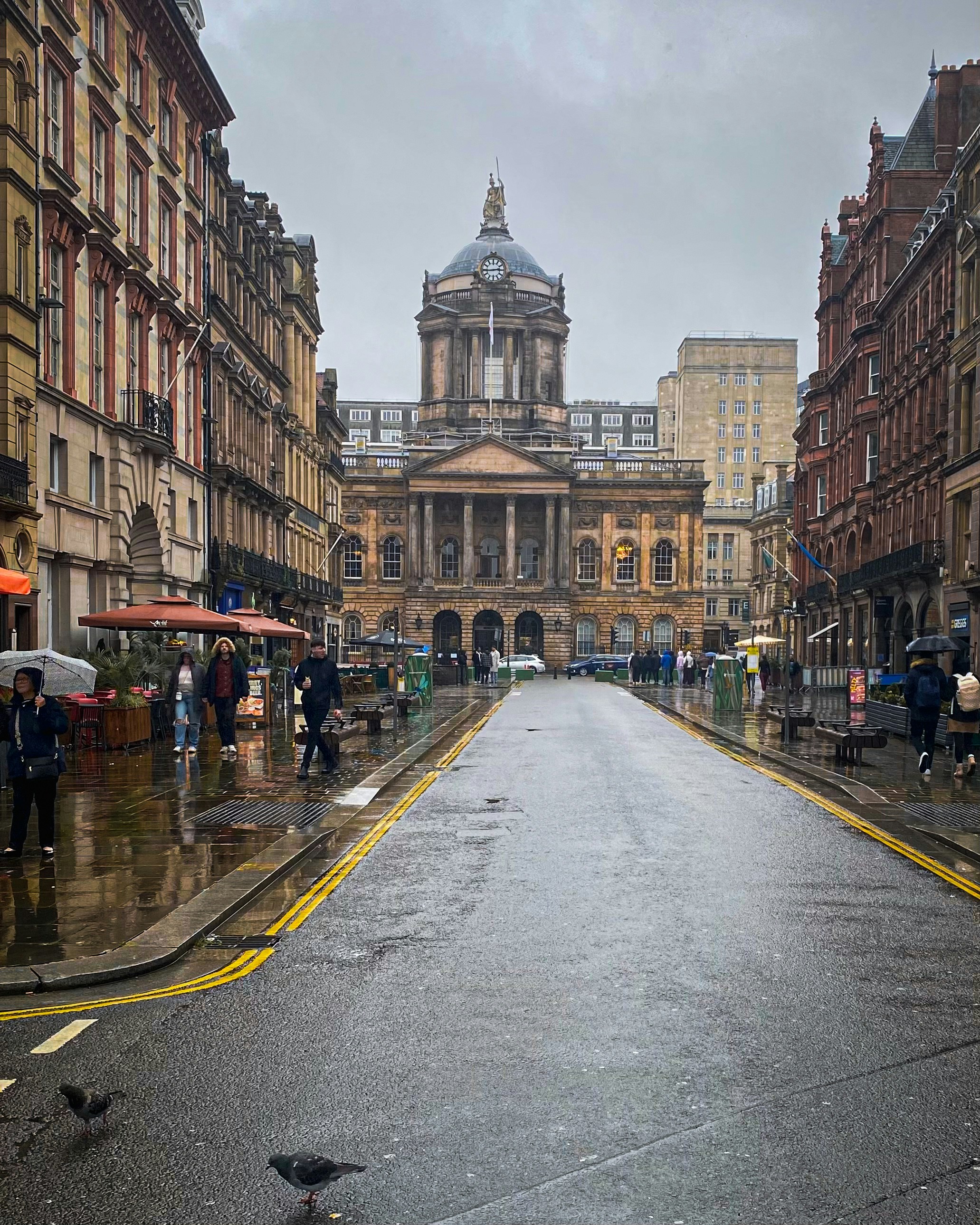 Rain-Streaked Avenue Converging on a Clock-Domed Civic Facade