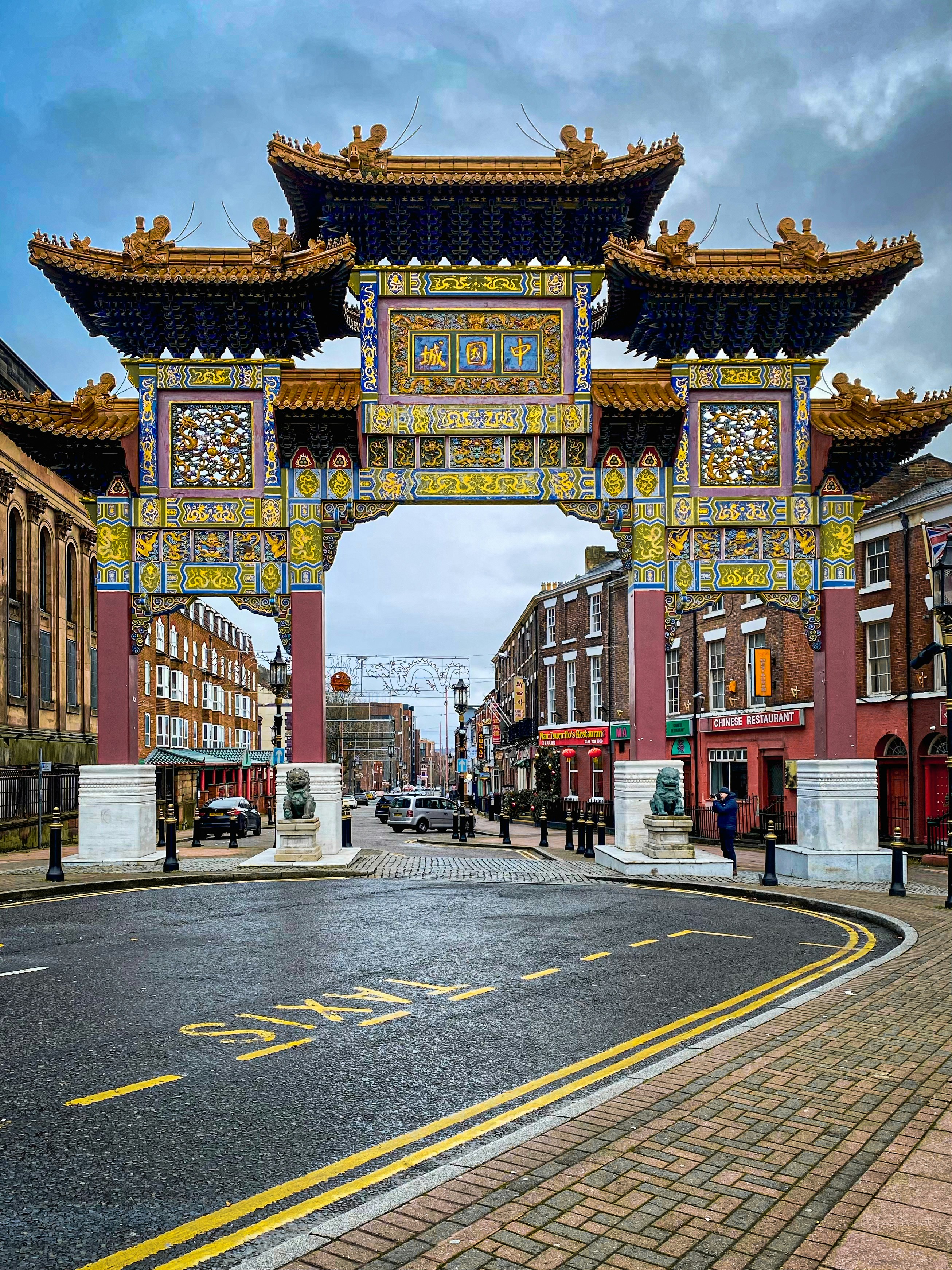Ornate Chinese Gate Framing a Brick-Fronted City Street