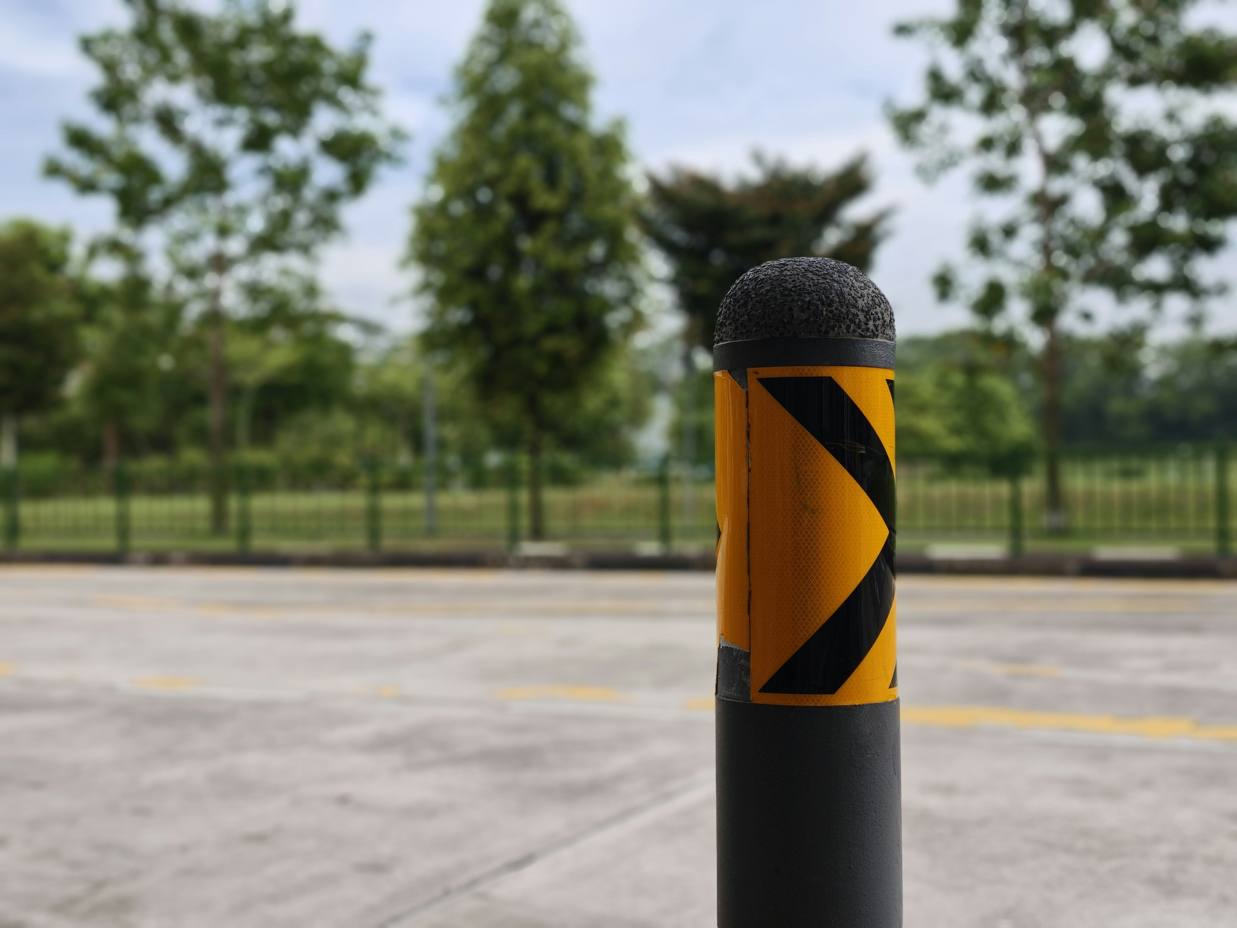 Yellow and black striped bollard in a park
