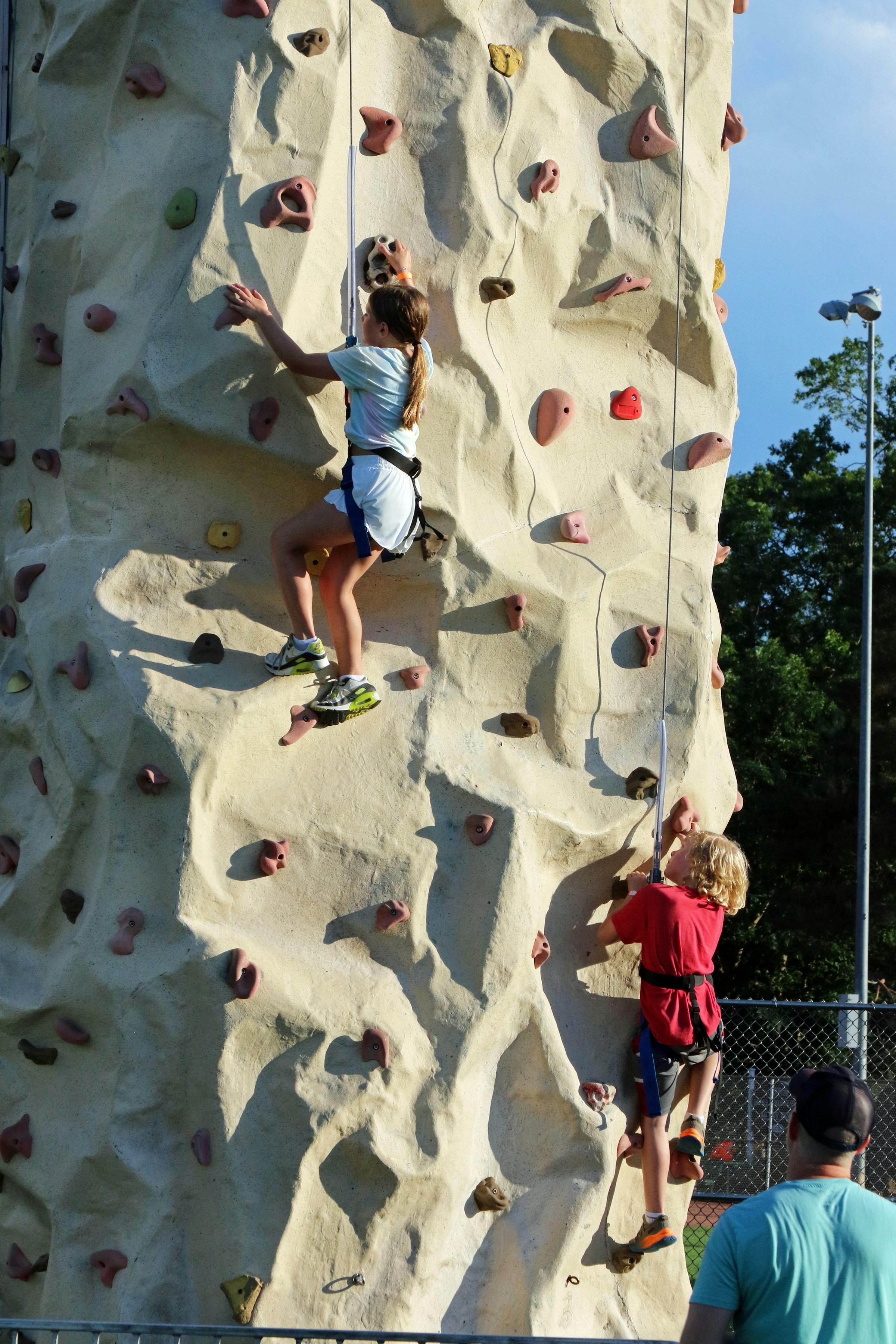 Sunlit Holds: Two Young Climbers Finding Their Grip