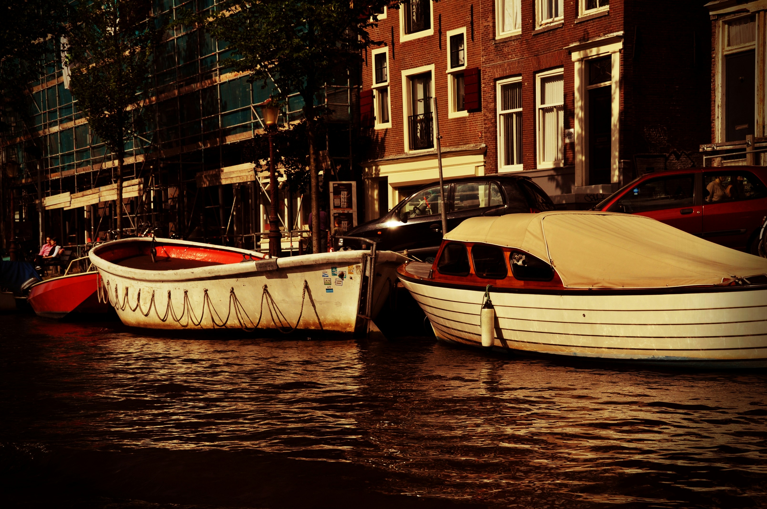 Dusk on the Canal: Boats Nestled Against Brick Facades in Copper-Tinted Glow