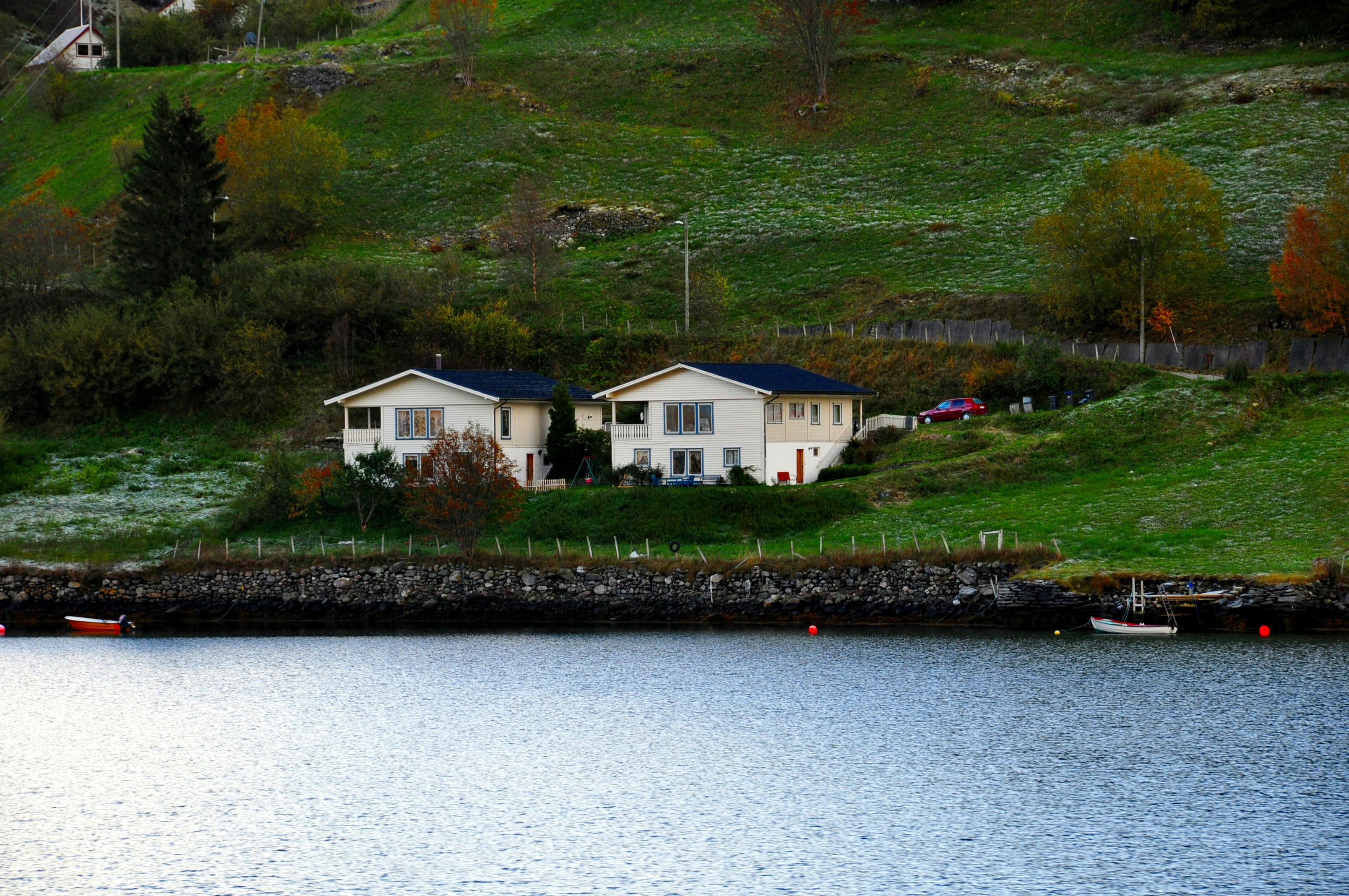 Twin White Cottages Along a Calm Lakeshore Beneath Autumn Hills