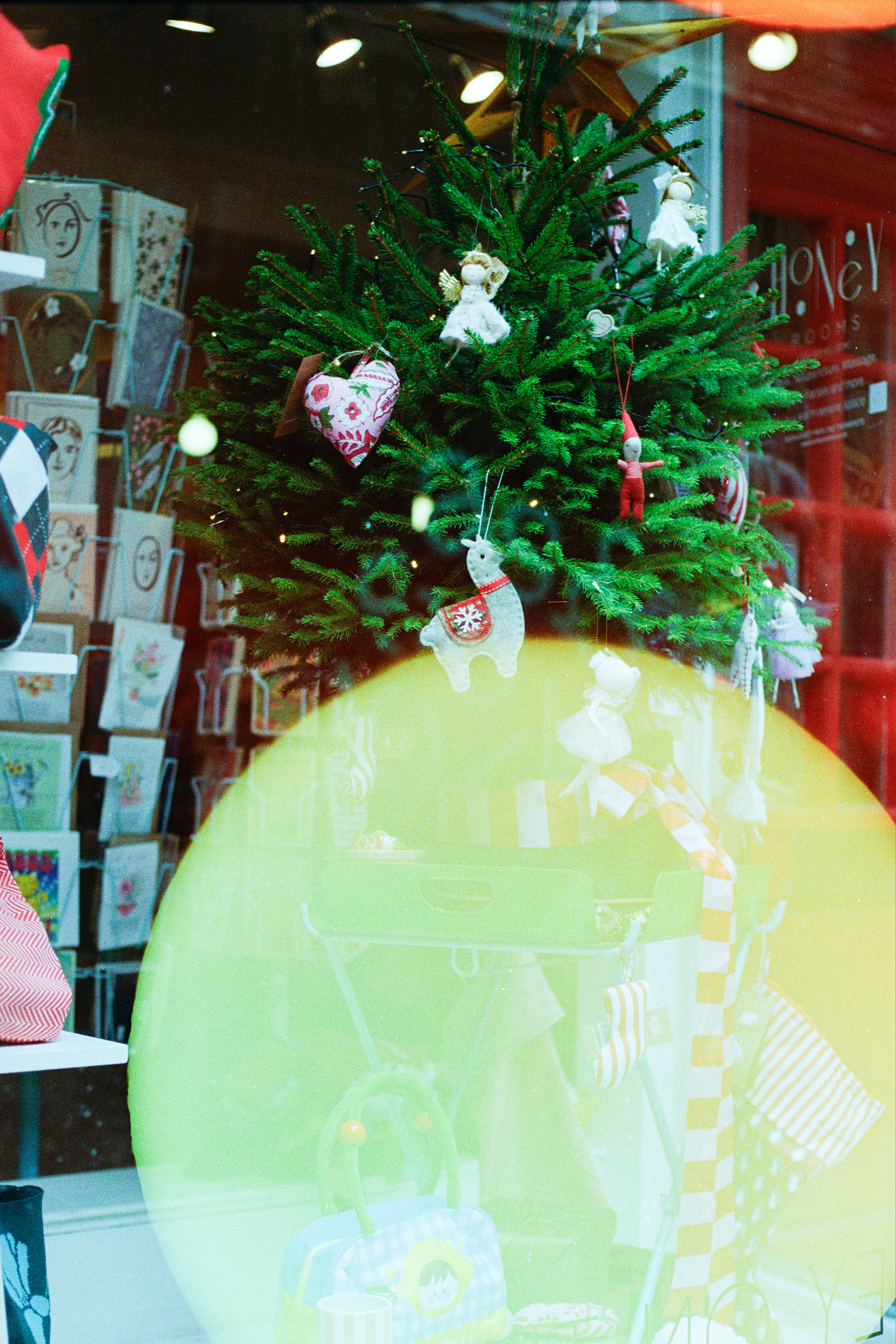 Christmas tree with ornaments in a shop window.