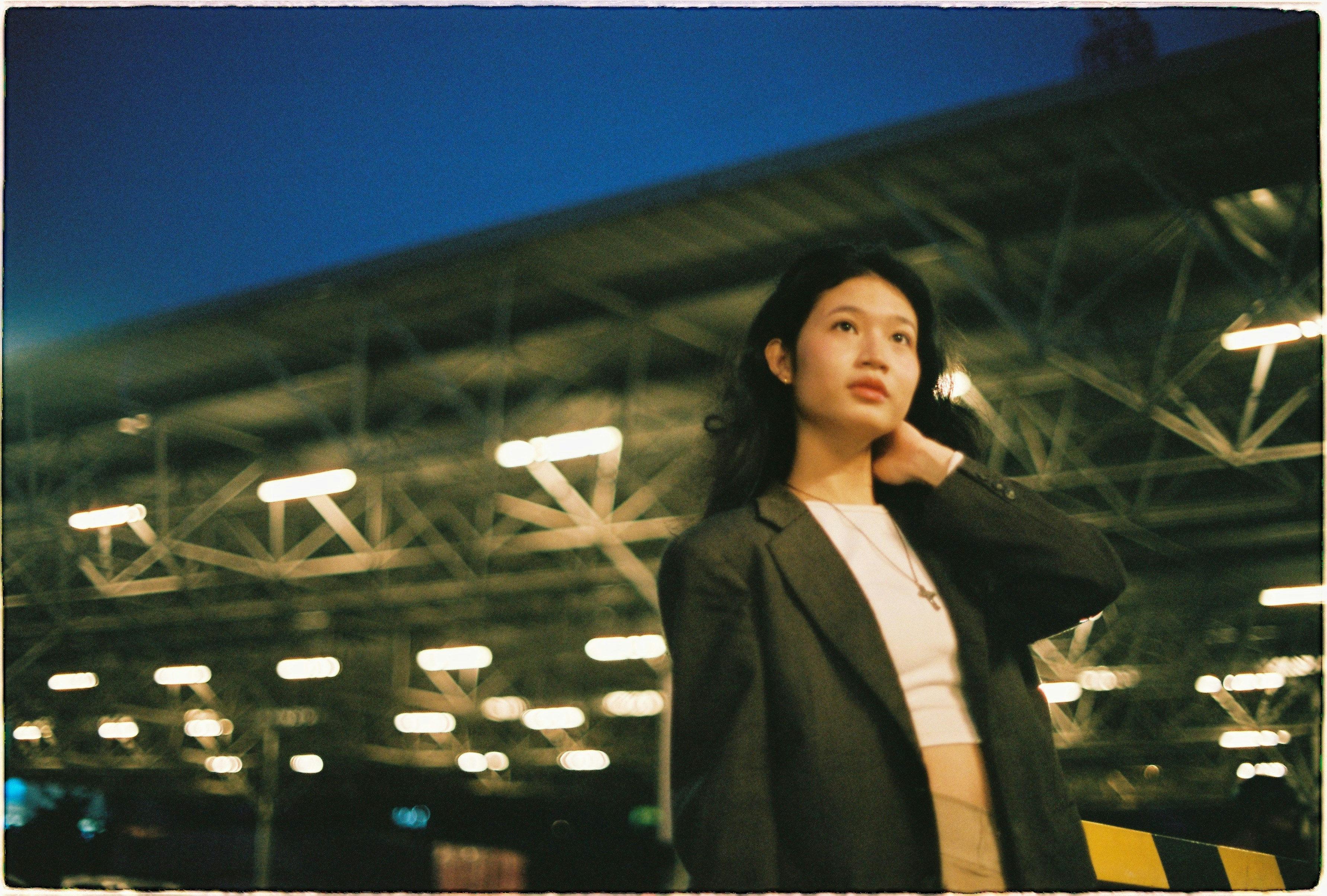 Under Neon Rafters: A Quiet Portrait in an Industrial Setting