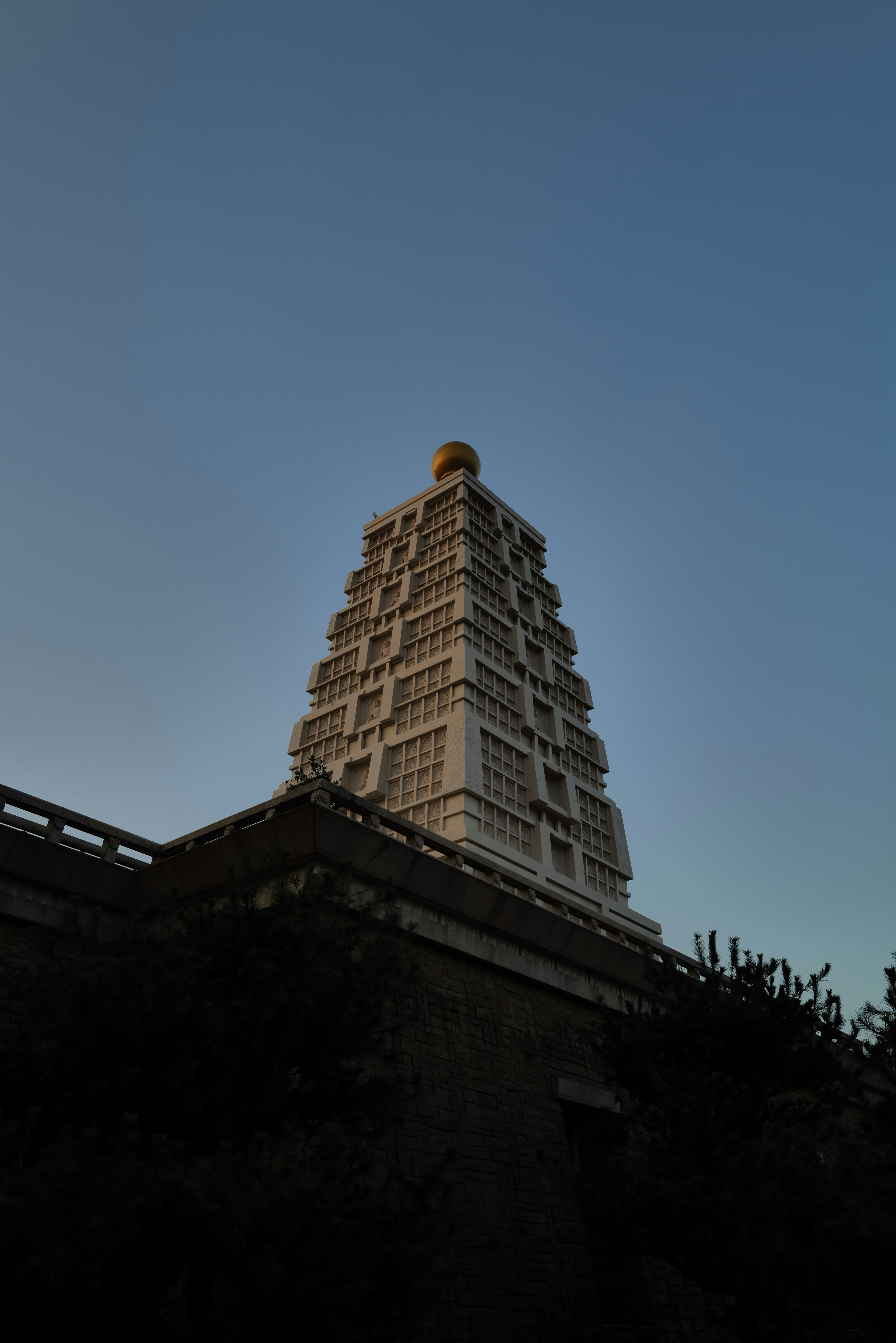 Golden Crowned Tiered Tower Against a Quiet Dusk Sky