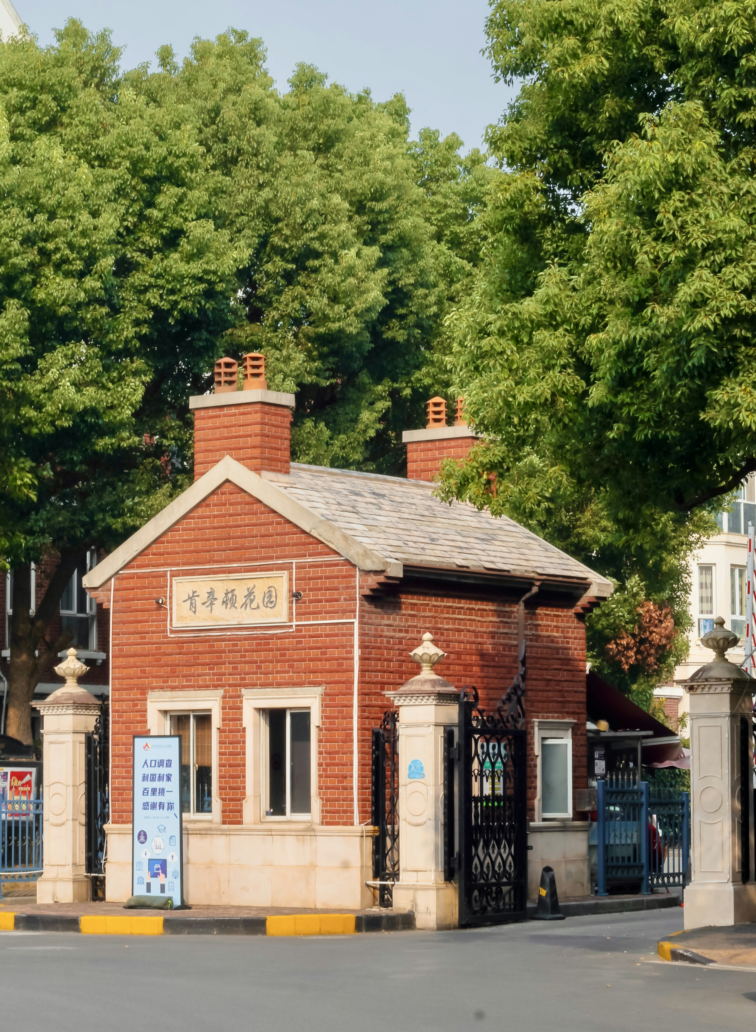 Small brick gatehouse with ornate metal gates and trees. photo – Free ...