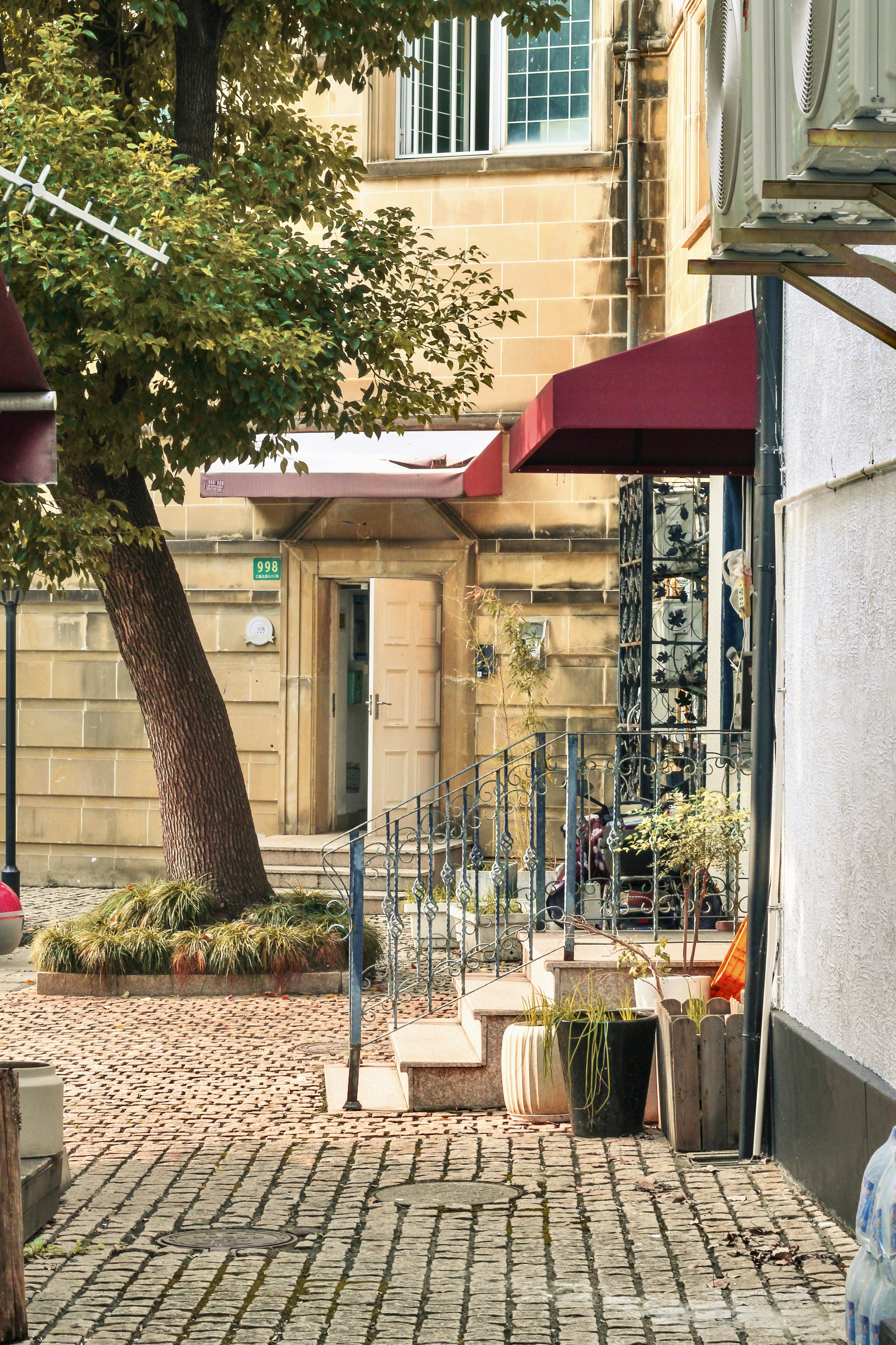 Doorway Under Red Awnings: A Quiet Courtyard on a Cobbled Street