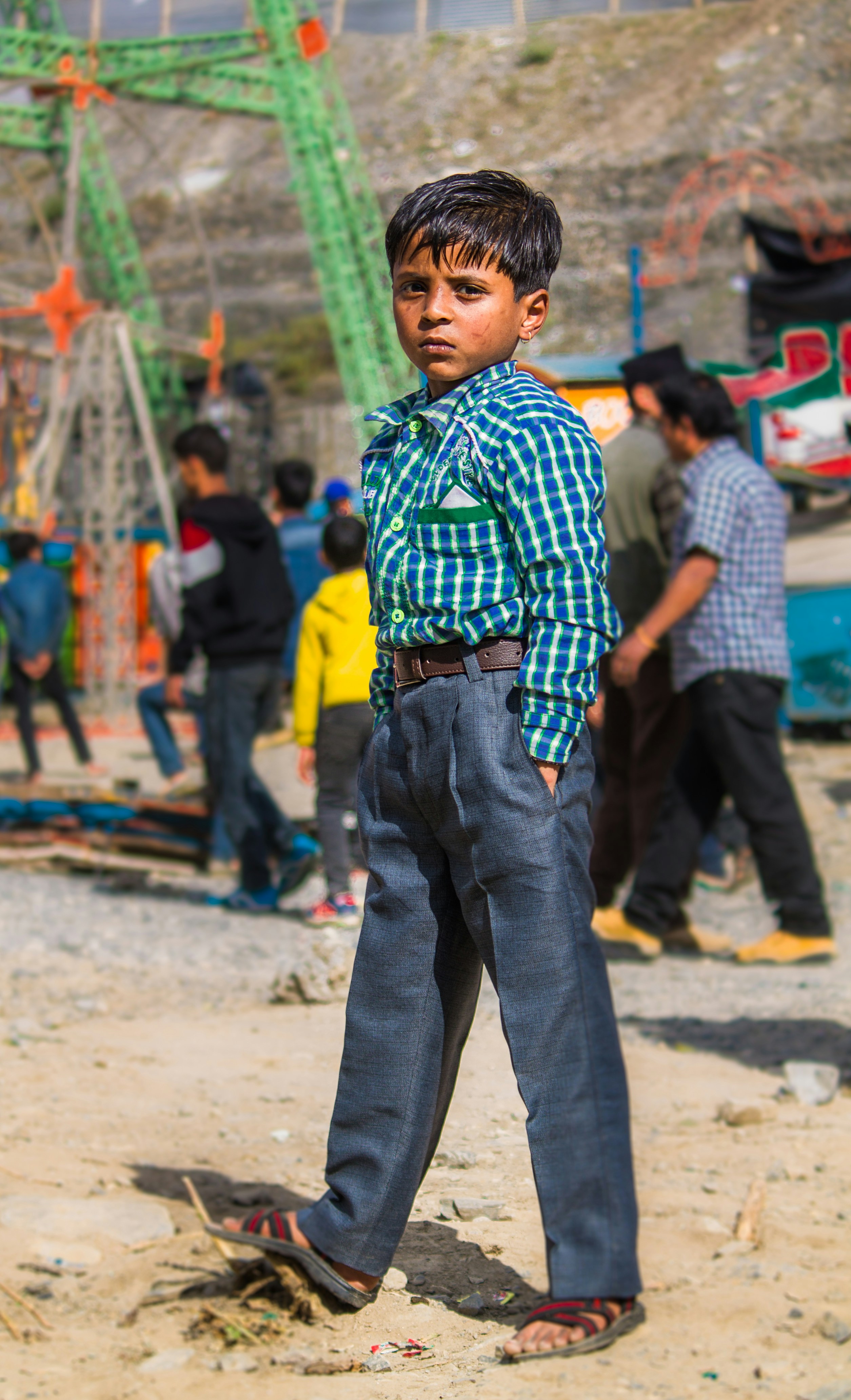 Blue Plaid in Focus: A Boy Stands Quiet Amid the Construction Buzz