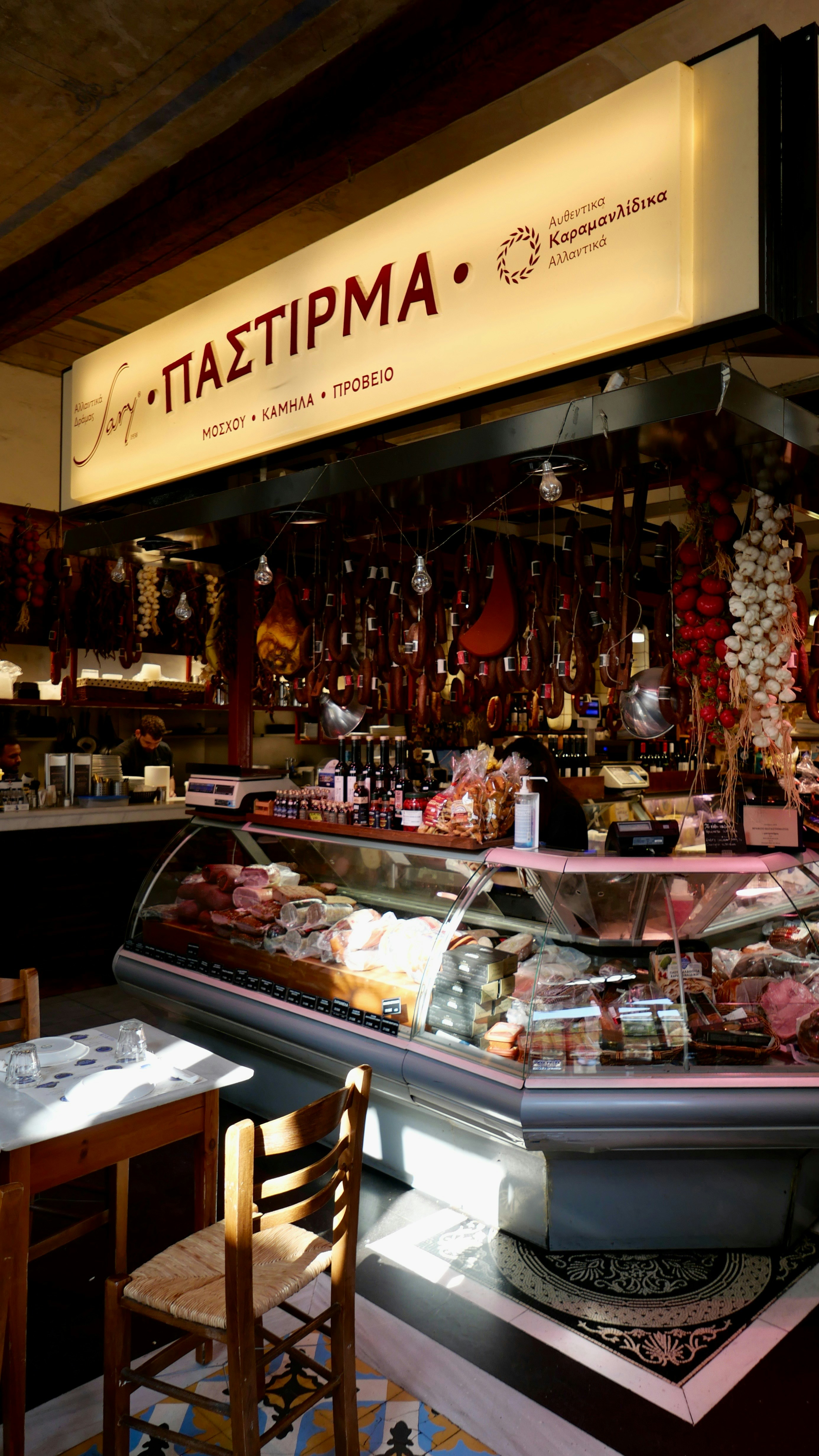 Butcher shop with hanging meats and display case.