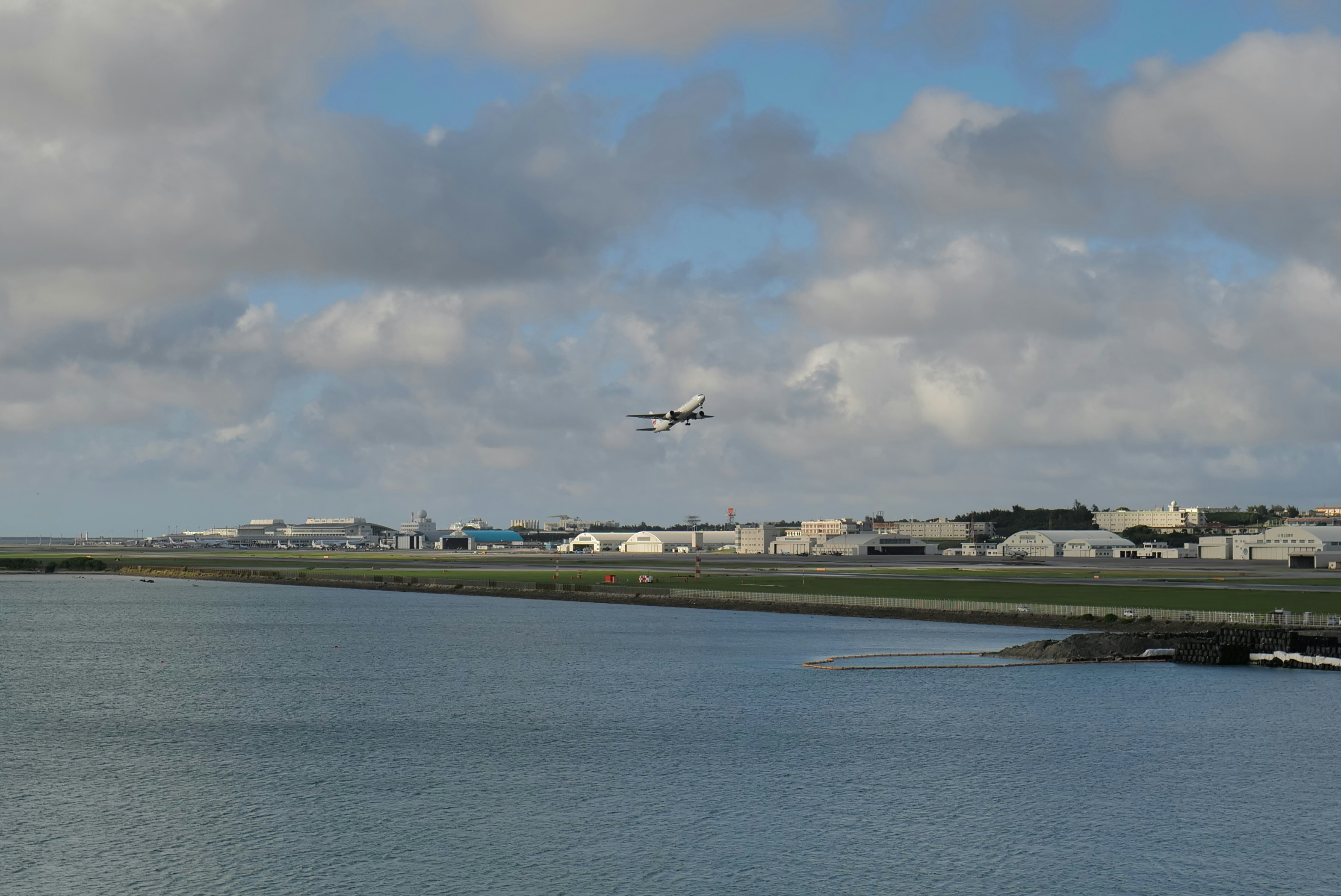 Coastal Takeoff: A Small Jet Climbing Over a Quiet Airfield