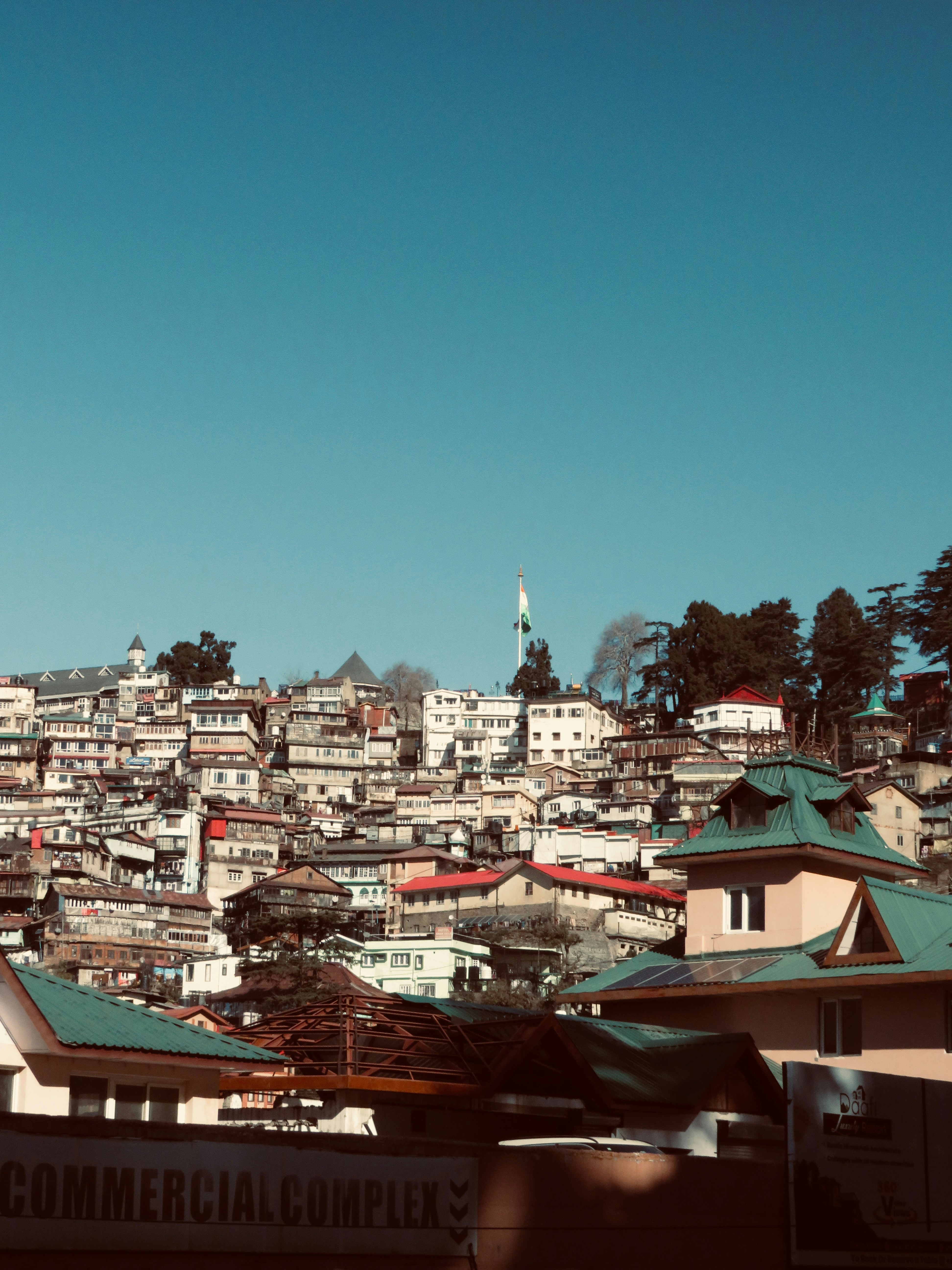 Flagpole Summit: A Patchwork Town Rises on the Hillside