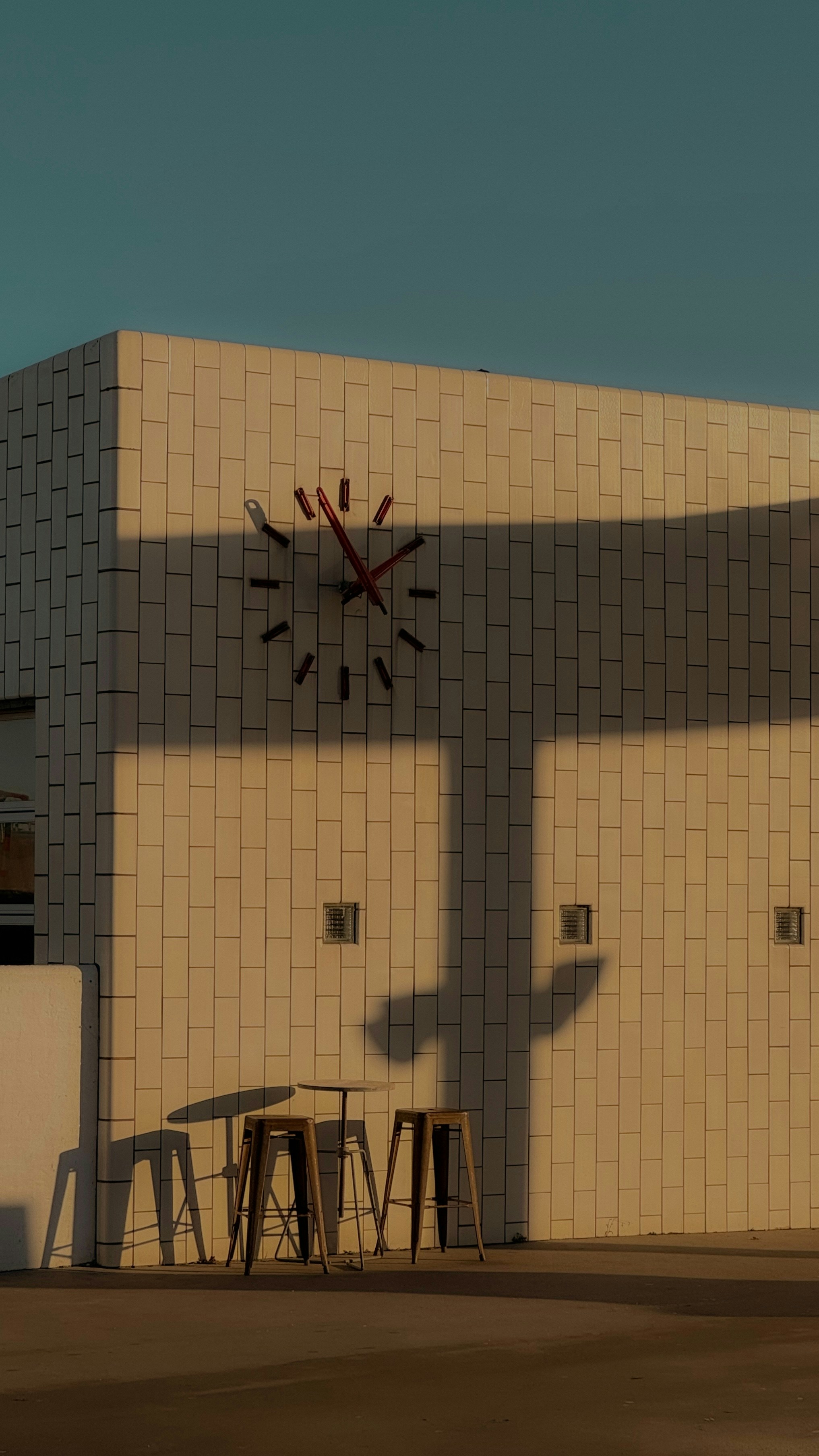 Clockface on a Sunlit Tiled Facade: Long Shadows and Quiet Geometry