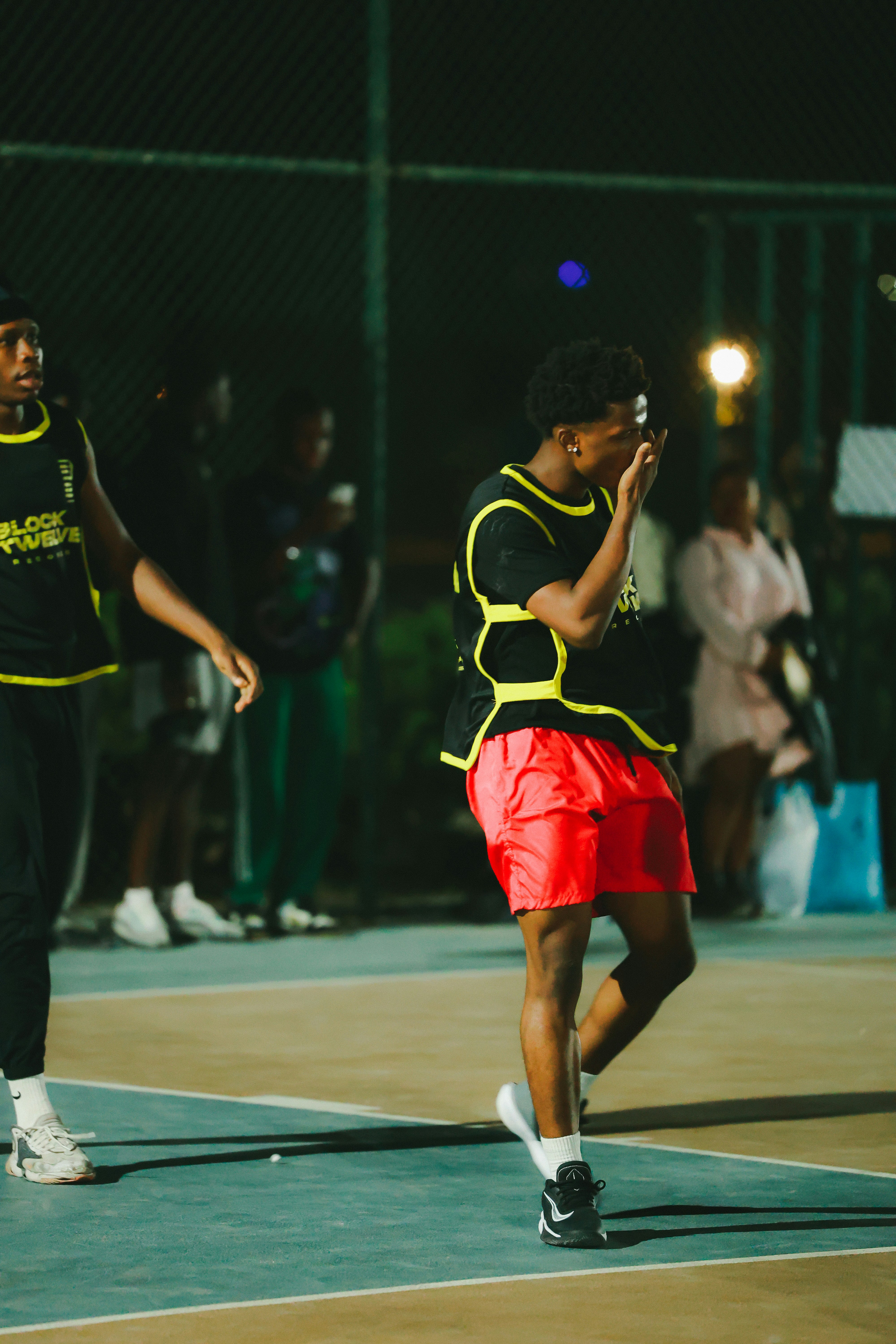 Neon Pulse on Night Court: A Player Pauses in the Outdoor Game