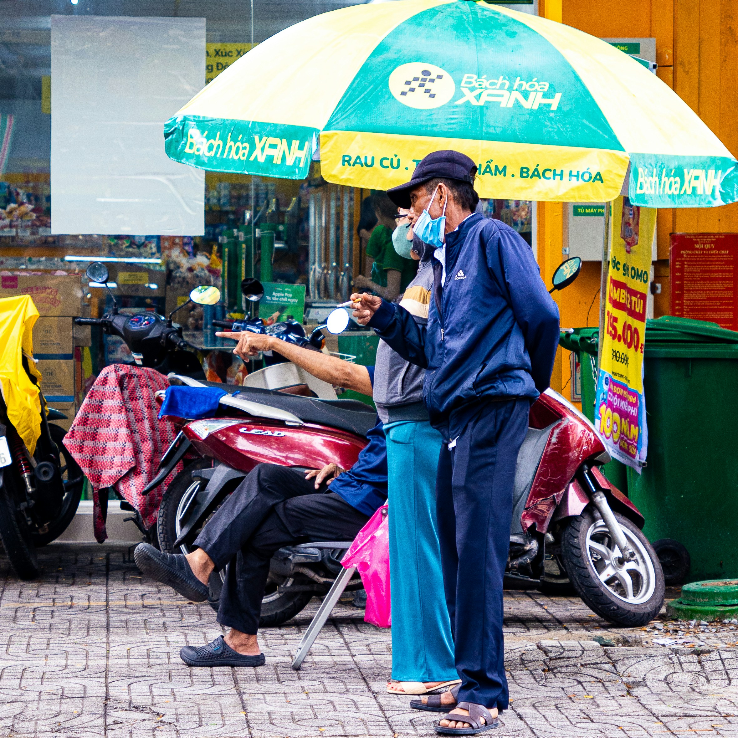 Blue-Suited Messenger Under a Market Umbrella in a Lively Vietnamese Street