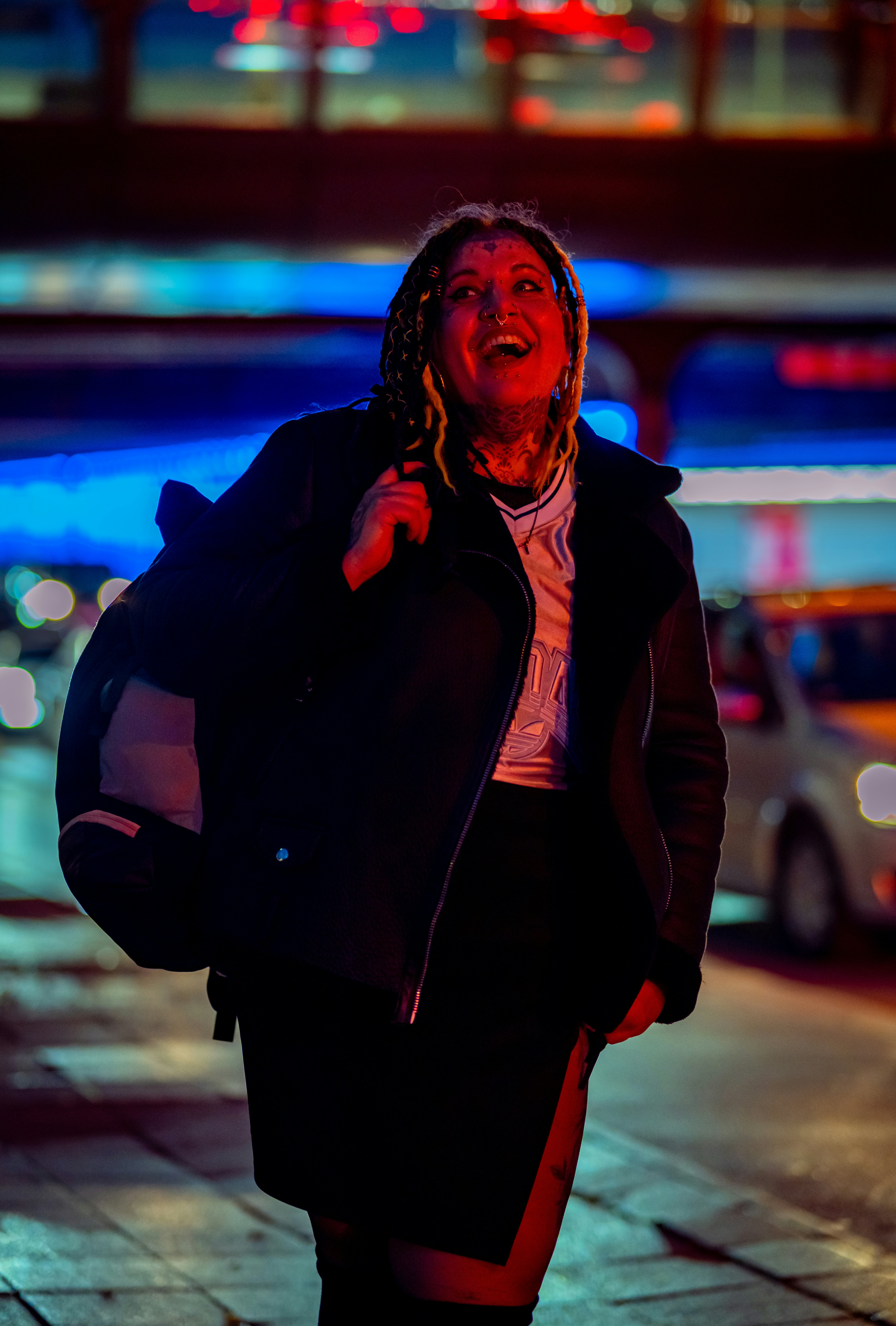 Neon Night Revelry: A Street Portrait Under Blue-Red Glare
