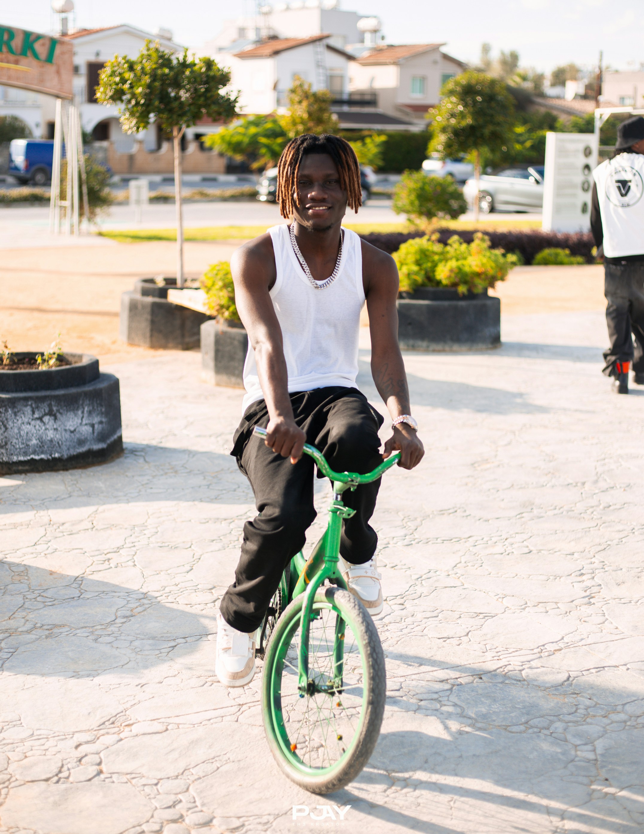 Sunlit plaza ride: a green bicycle and a beaming rider