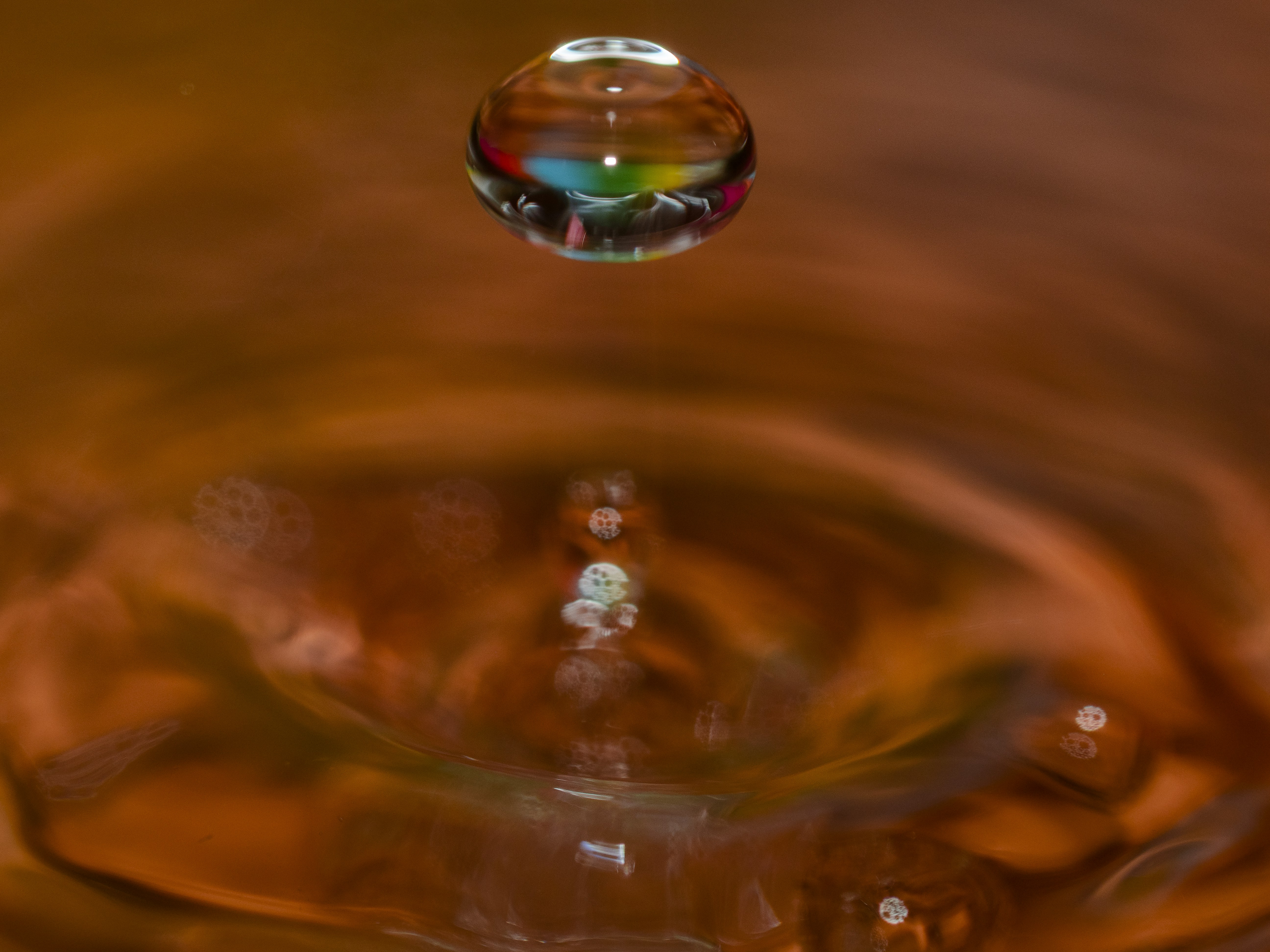 Copper Orbit: a Droplet Suspended Over a Molten Ripple