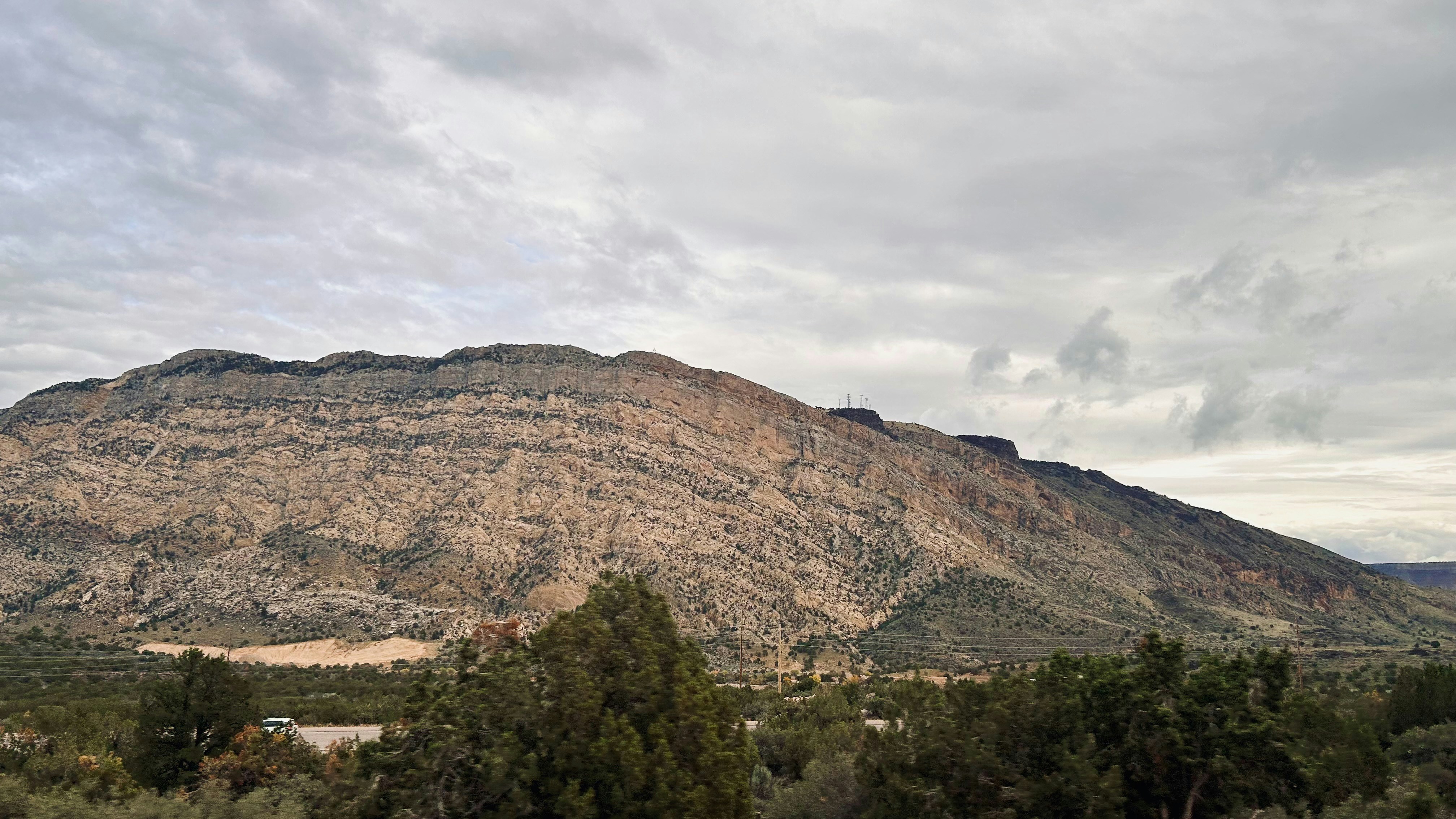 Rust-Tinted Mesa Ridge Under a Cloudy Sky