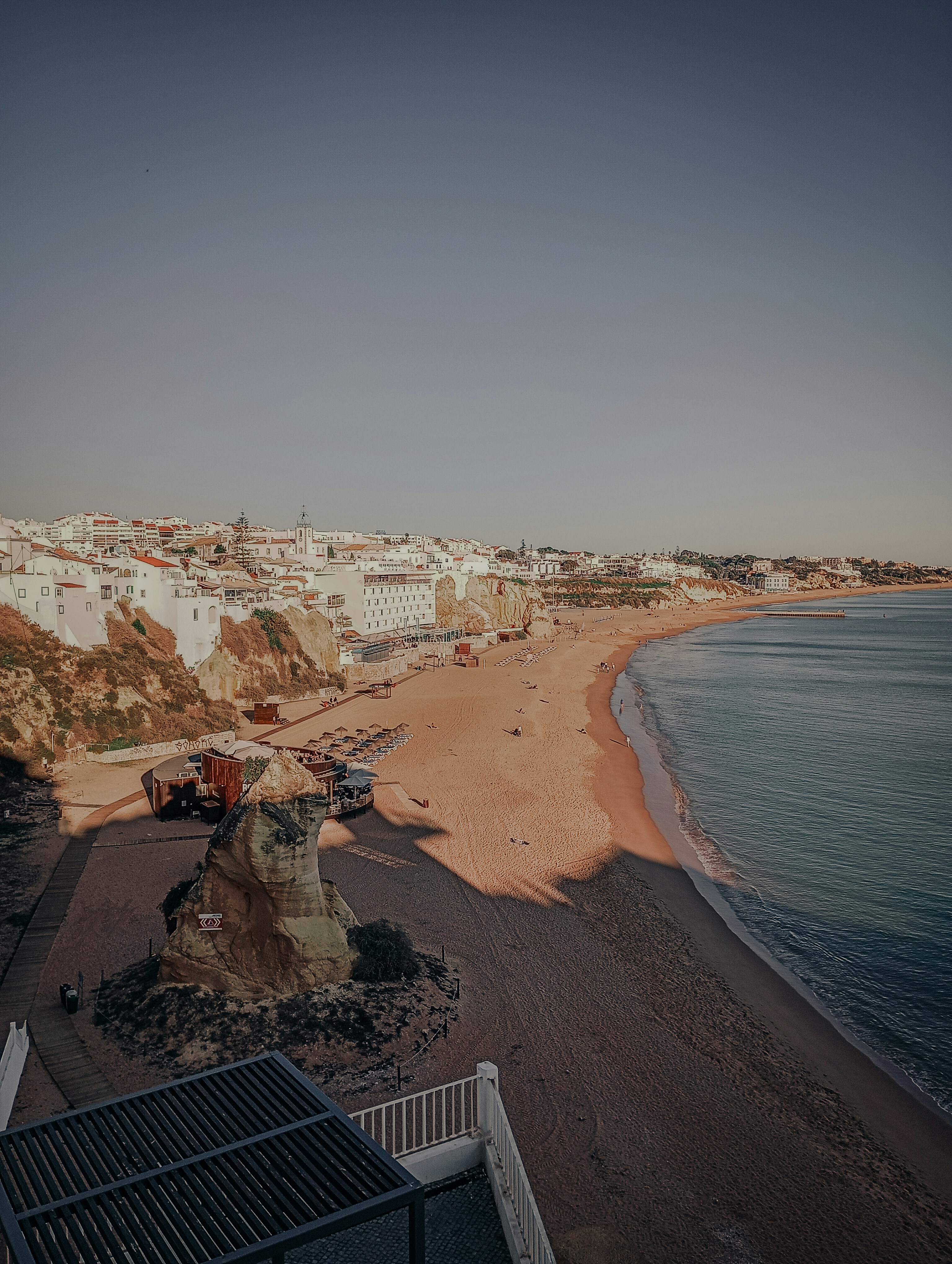 Coastal town with sandy beach and ocean waves.