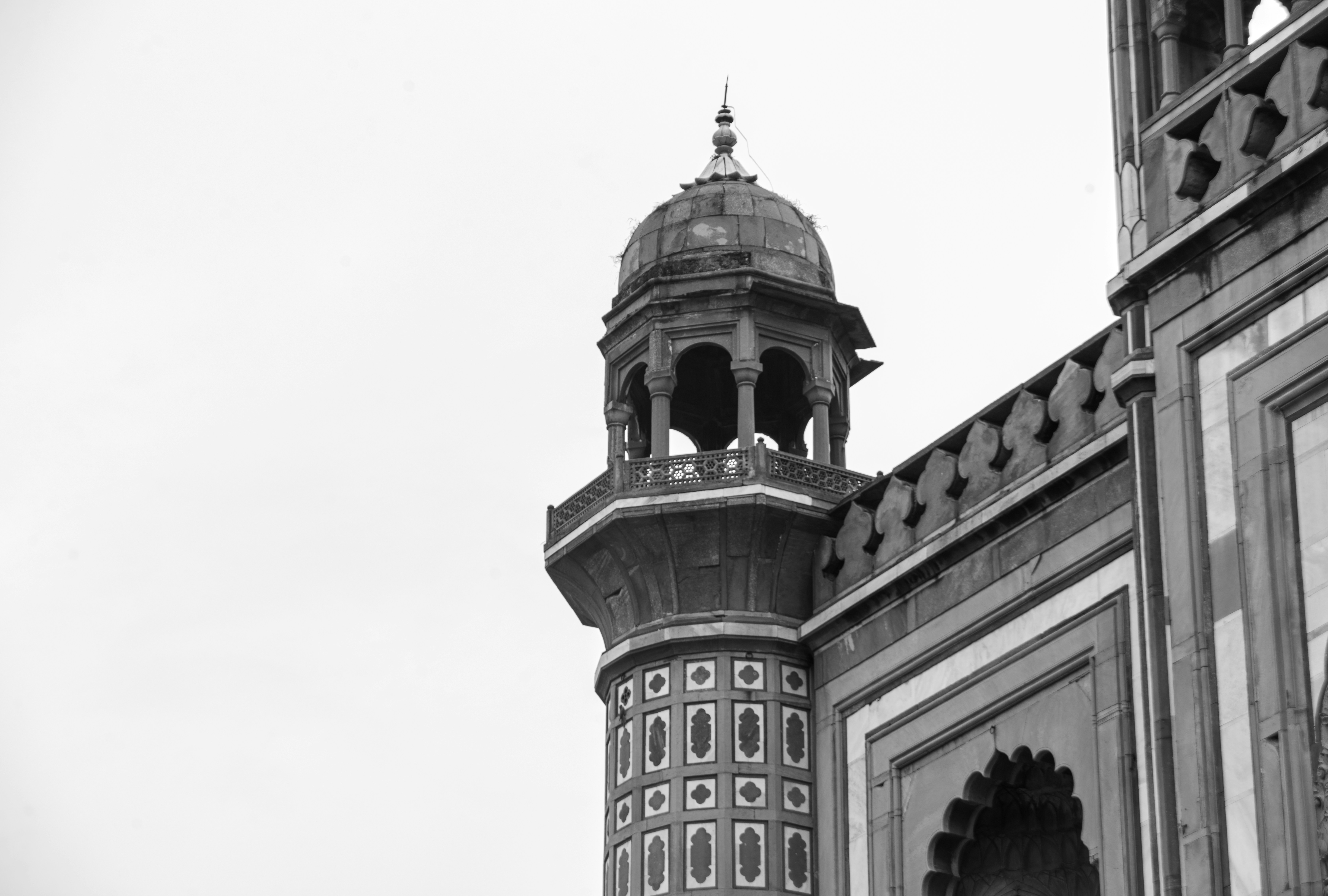 One of four slender minarets at the corners of Safdarjung's Tomb. They are part of the main structure, which is a distinctive feature compared to the Taj Mahal, where the towers are detached. These minarets are part of the main building and are adorned with delicate embellishments, adding to the overall grandeur of the tomb, which is also known for its intricate latticework and calligraphy.