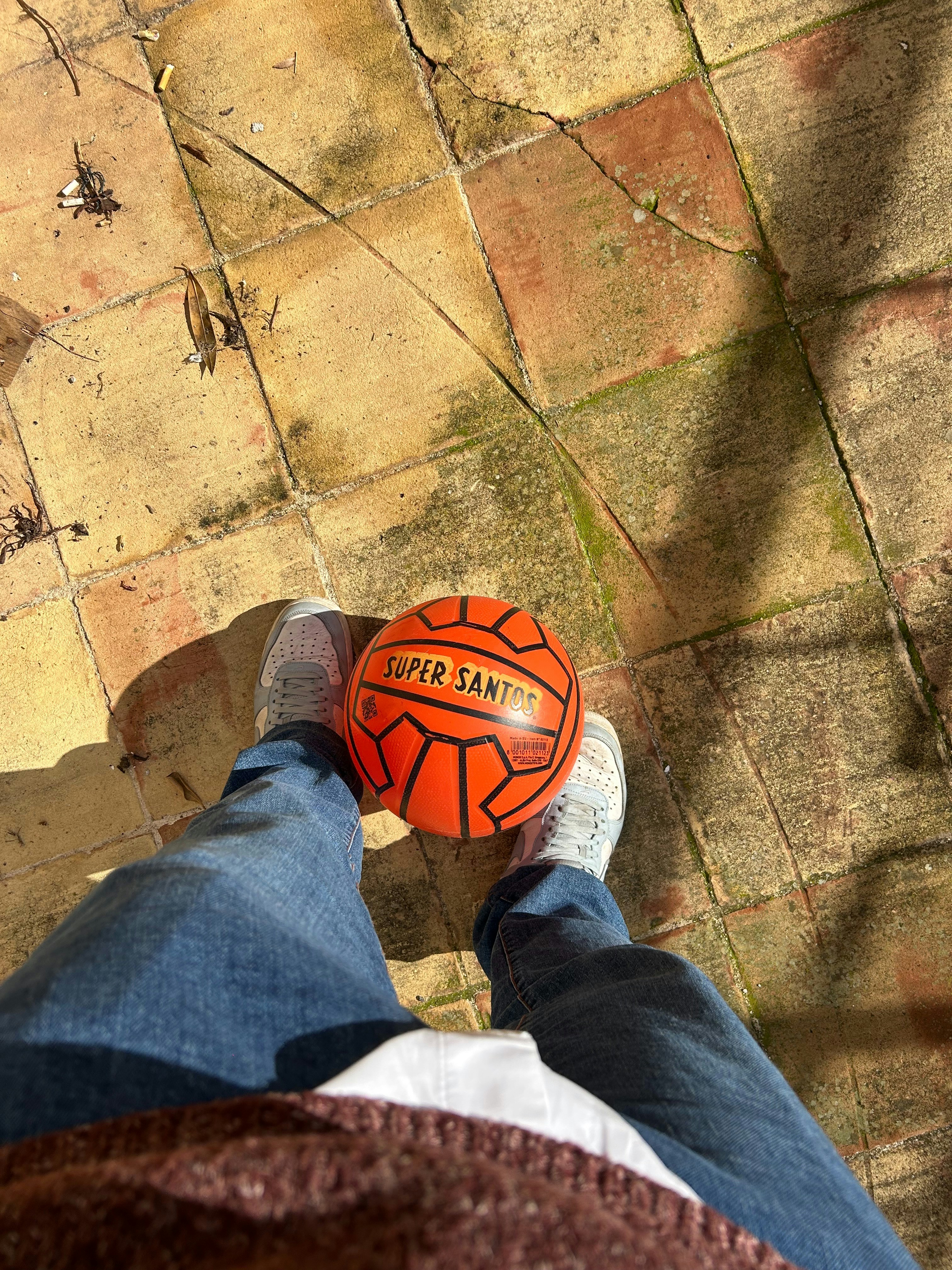 Top-Down Play: Basketball and Shoes on Sunlit Tiles
