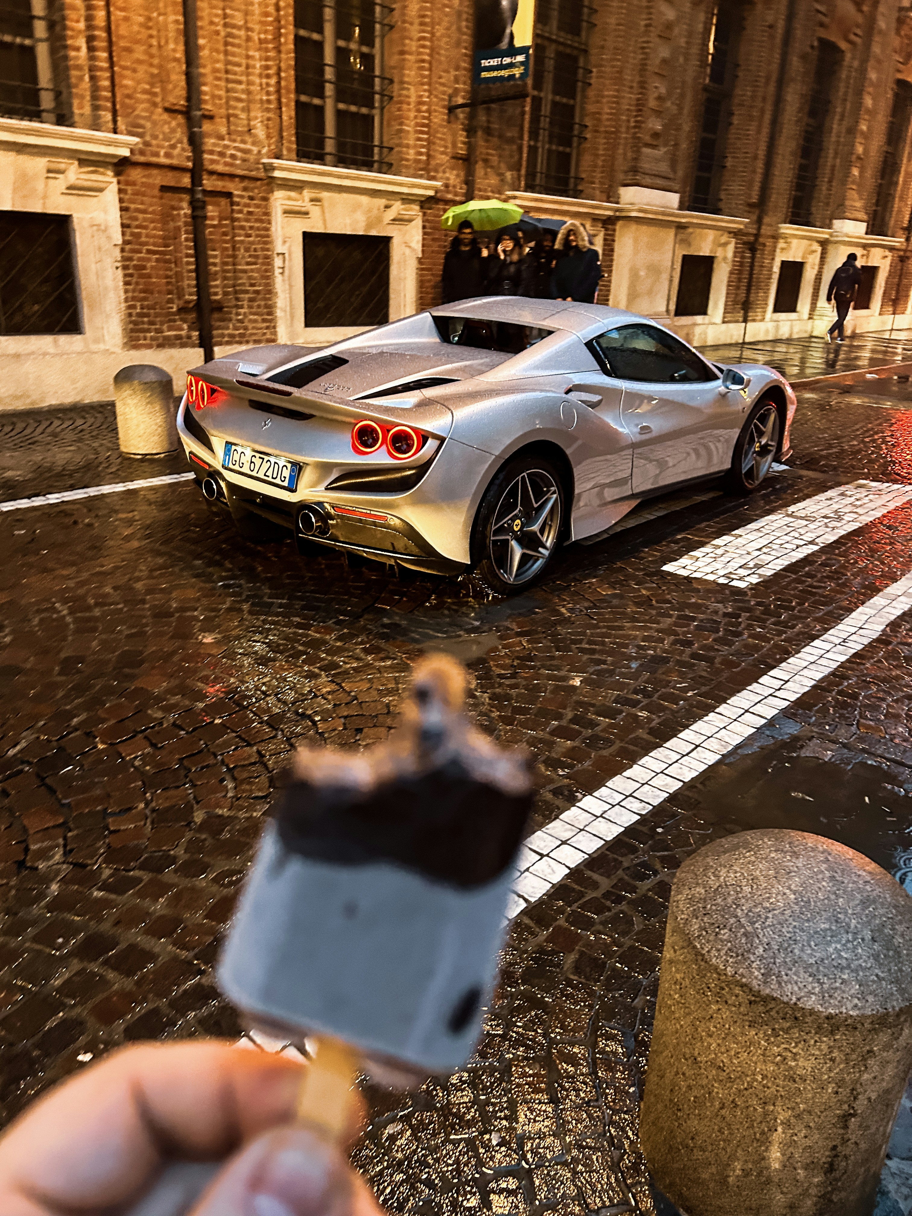 Rain-Glossed Ferrari on a Cobblestoned City Street at Night