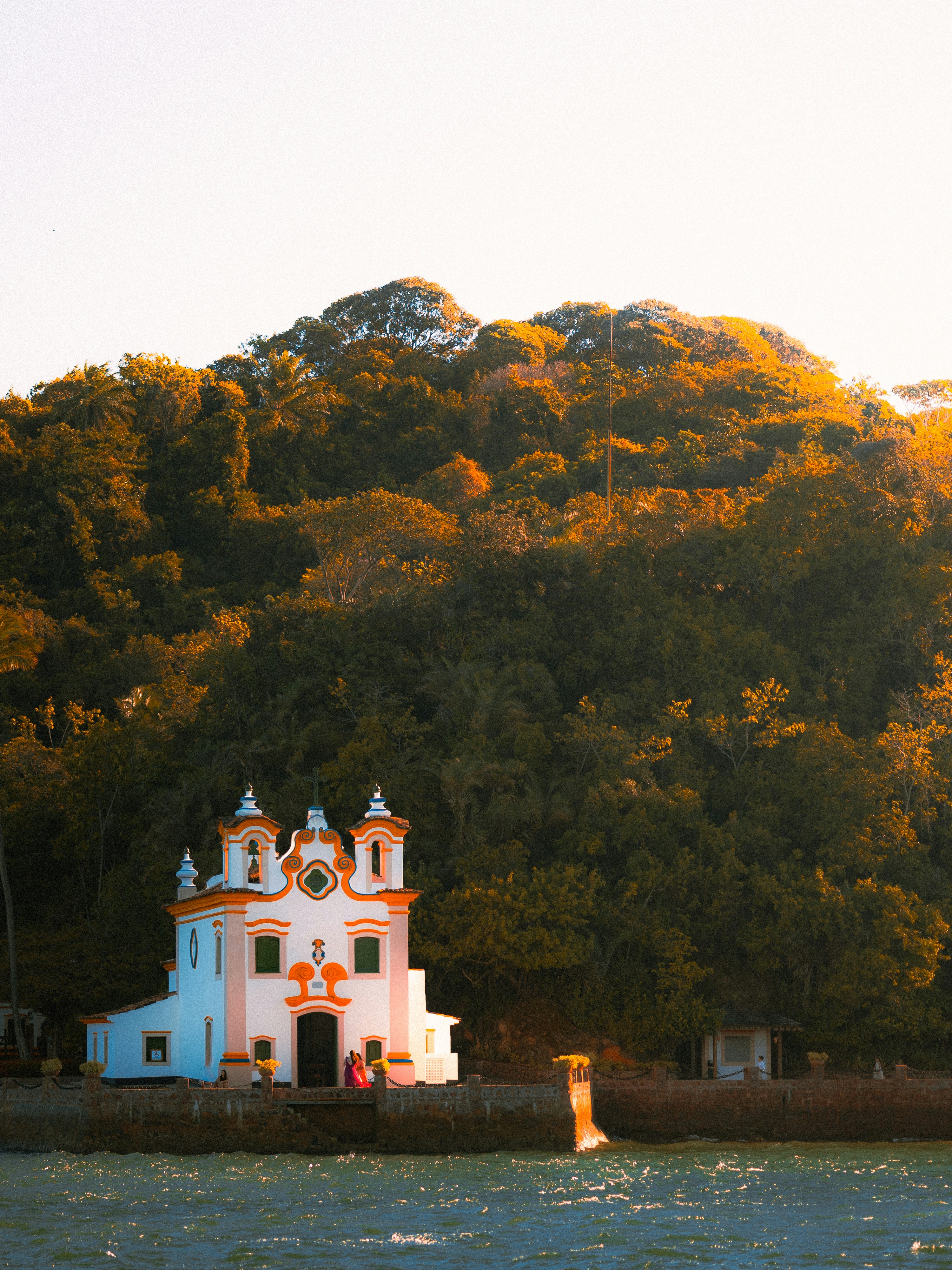 Azure Chapel at the Lakefront Beneath a Sunlit Hillside