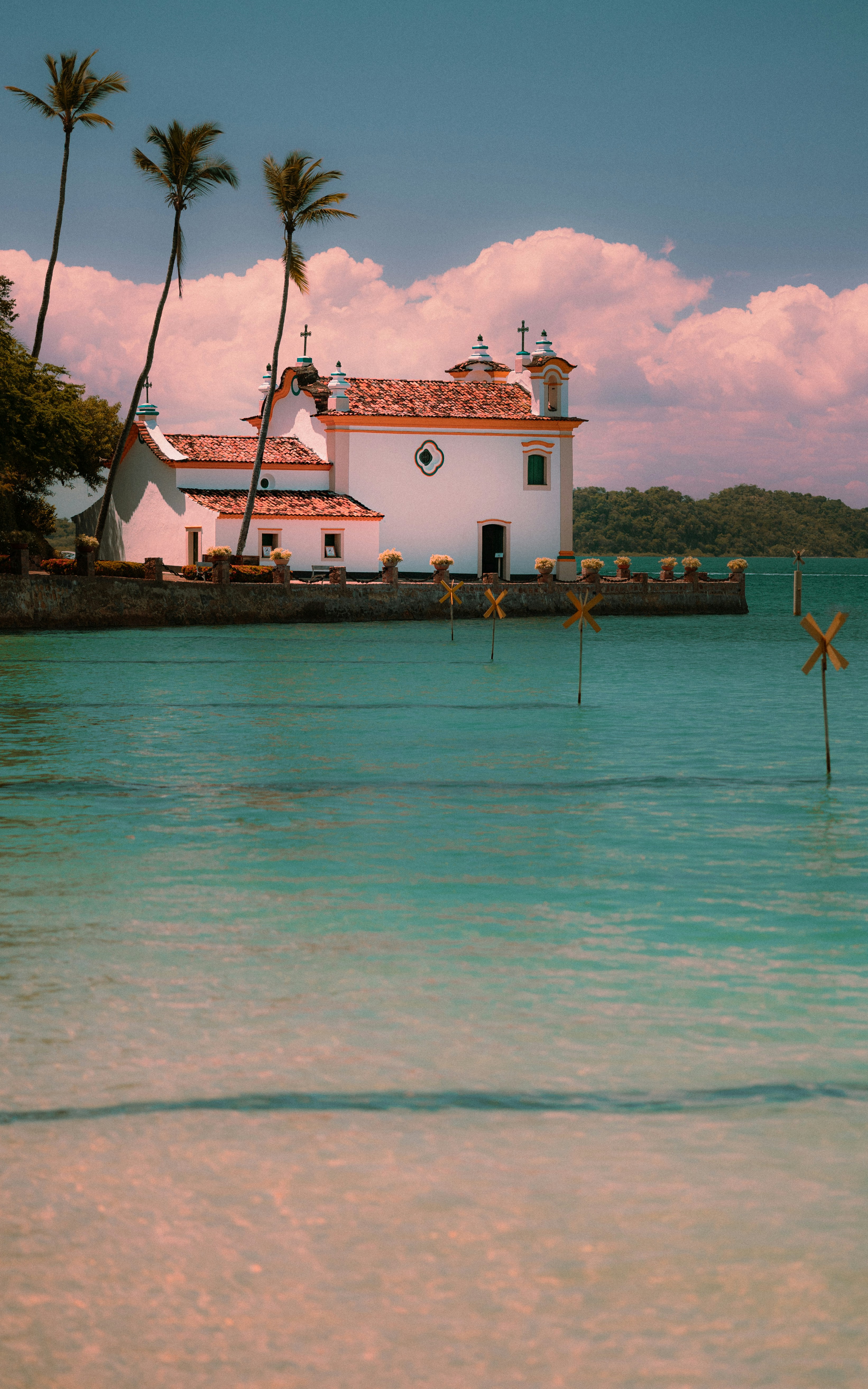 White Chapel Beside Turquoise Waters under Coral-Pink Clouds