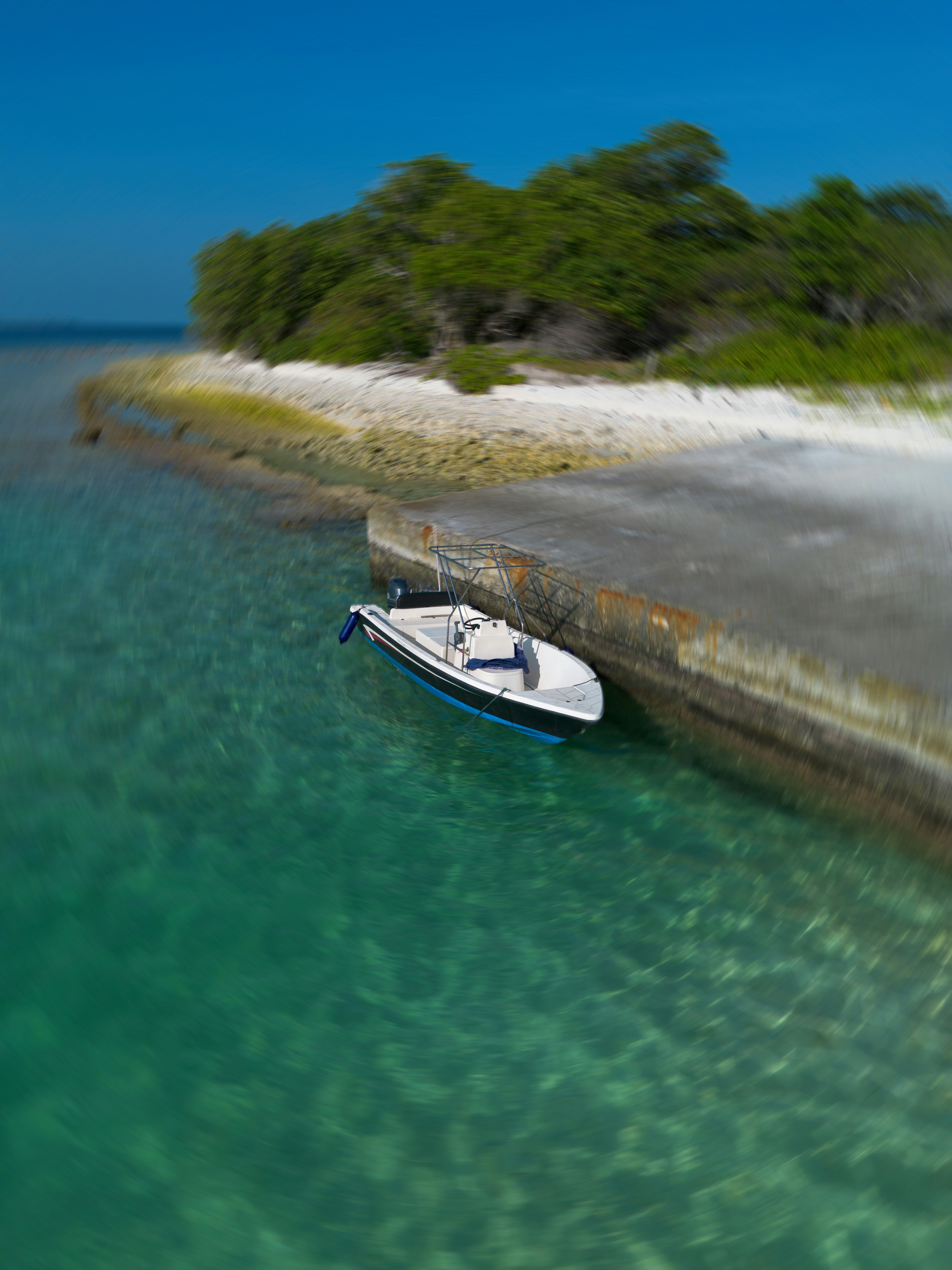 Turquoise Coastline: A Small Boat by a Weathered Jetty