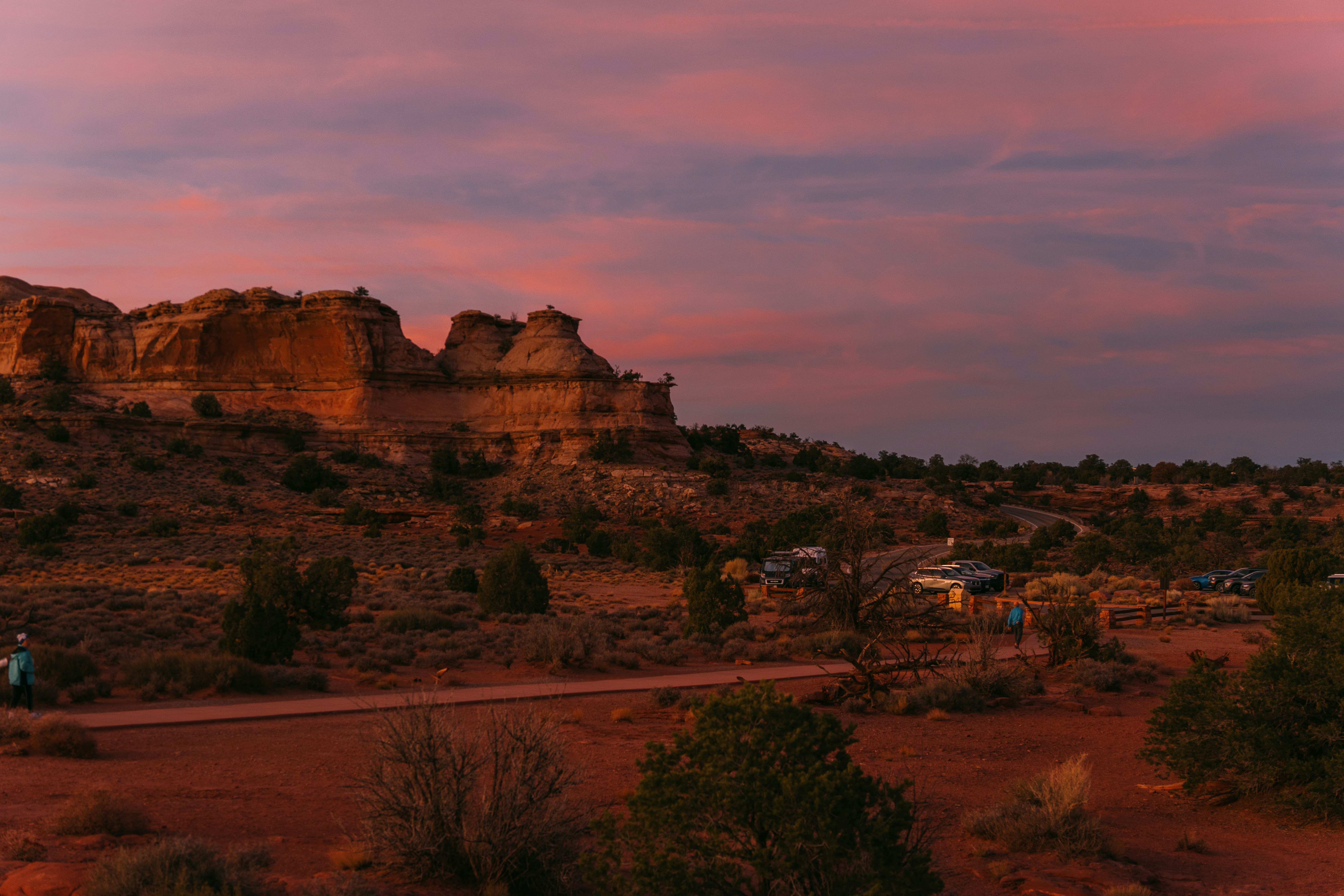 Coral Dusk Over Red Rock Cliffs and Desert Road
