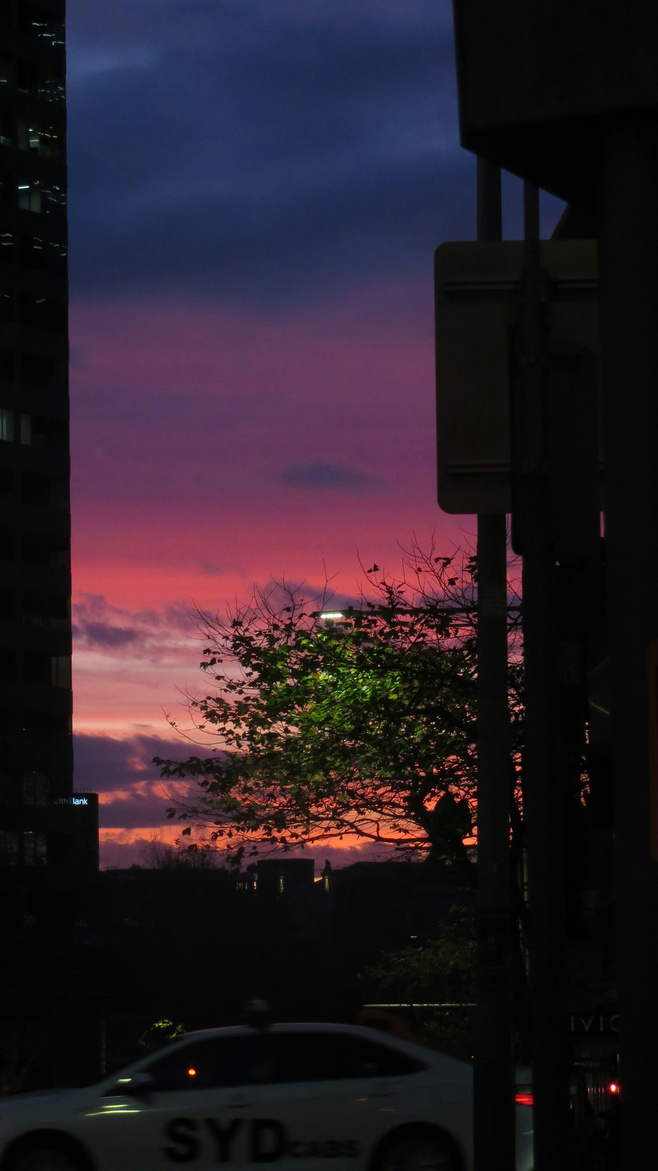 Vibrant sunset sky over a city street.