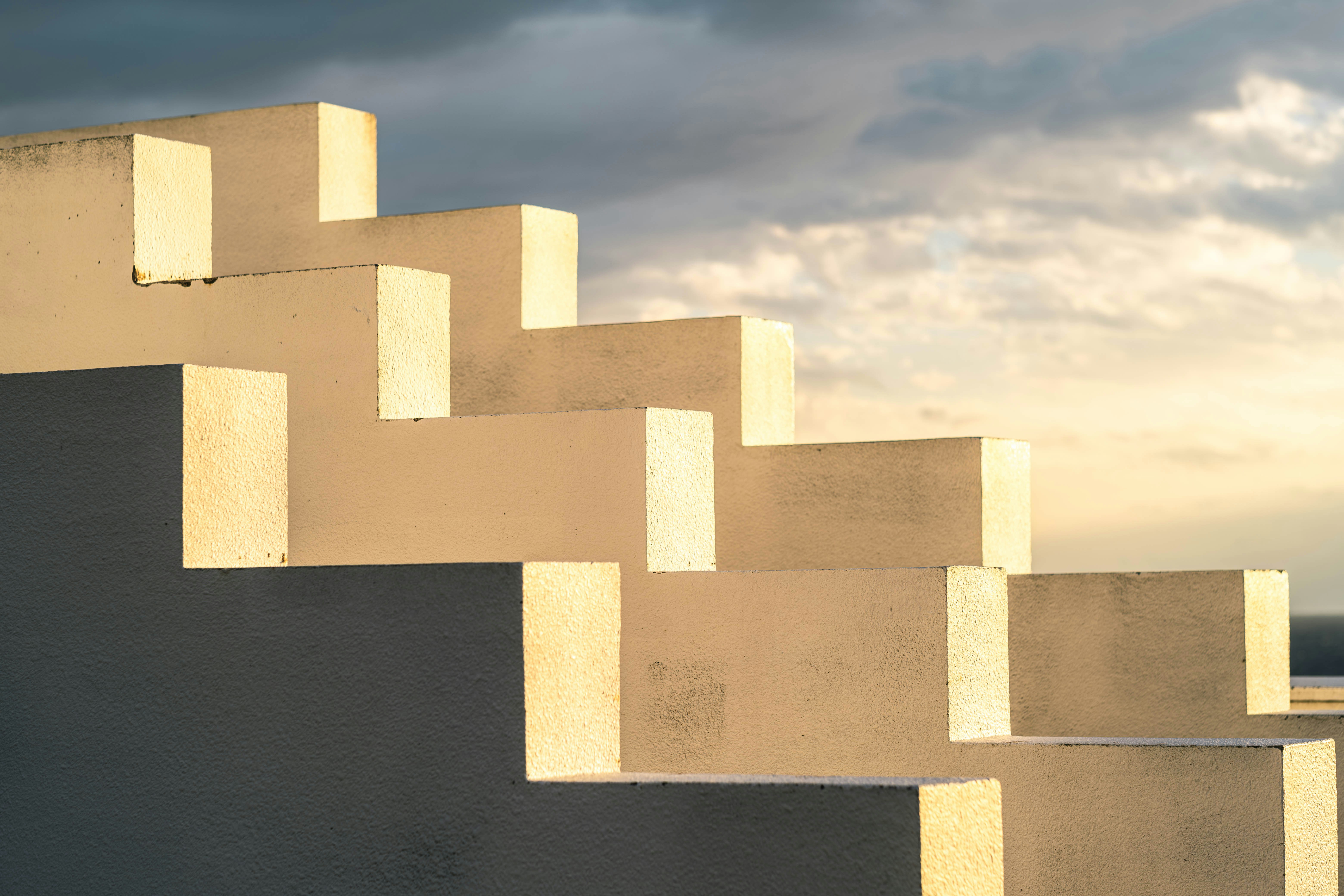 Golden Cadence: Sunlit Concrete Steps in a Geometric Stairway