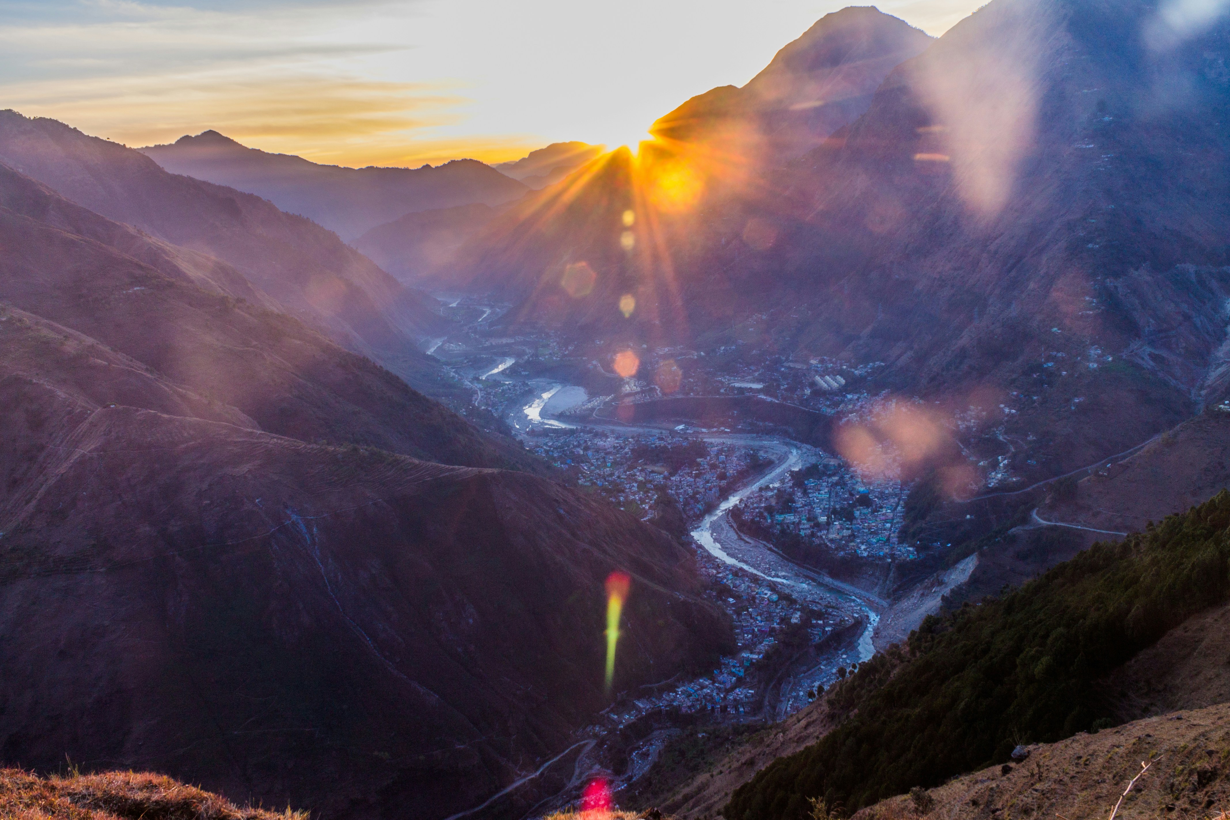 Dawn's Starburst Over a Winding Alpine Valley