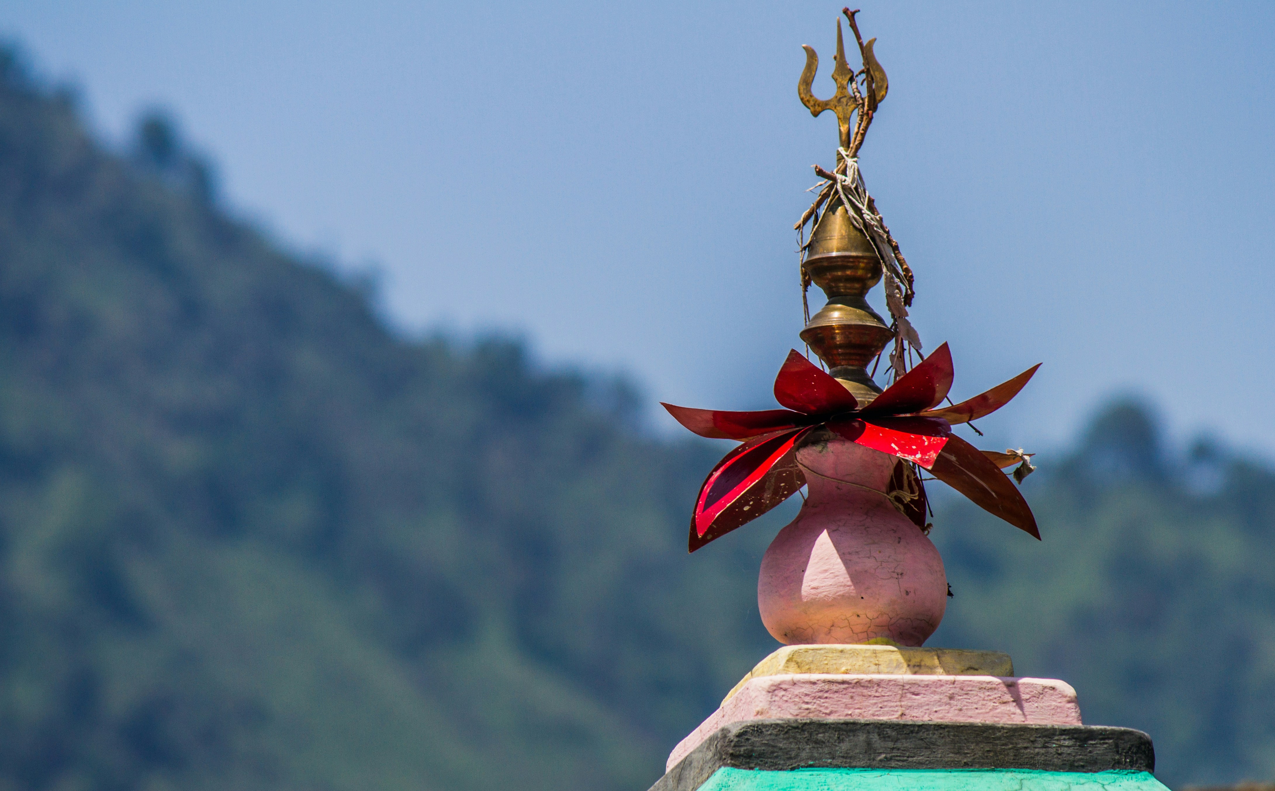 Crimson Spire Crowned by Metal Petals Against a Mountain Horizon
