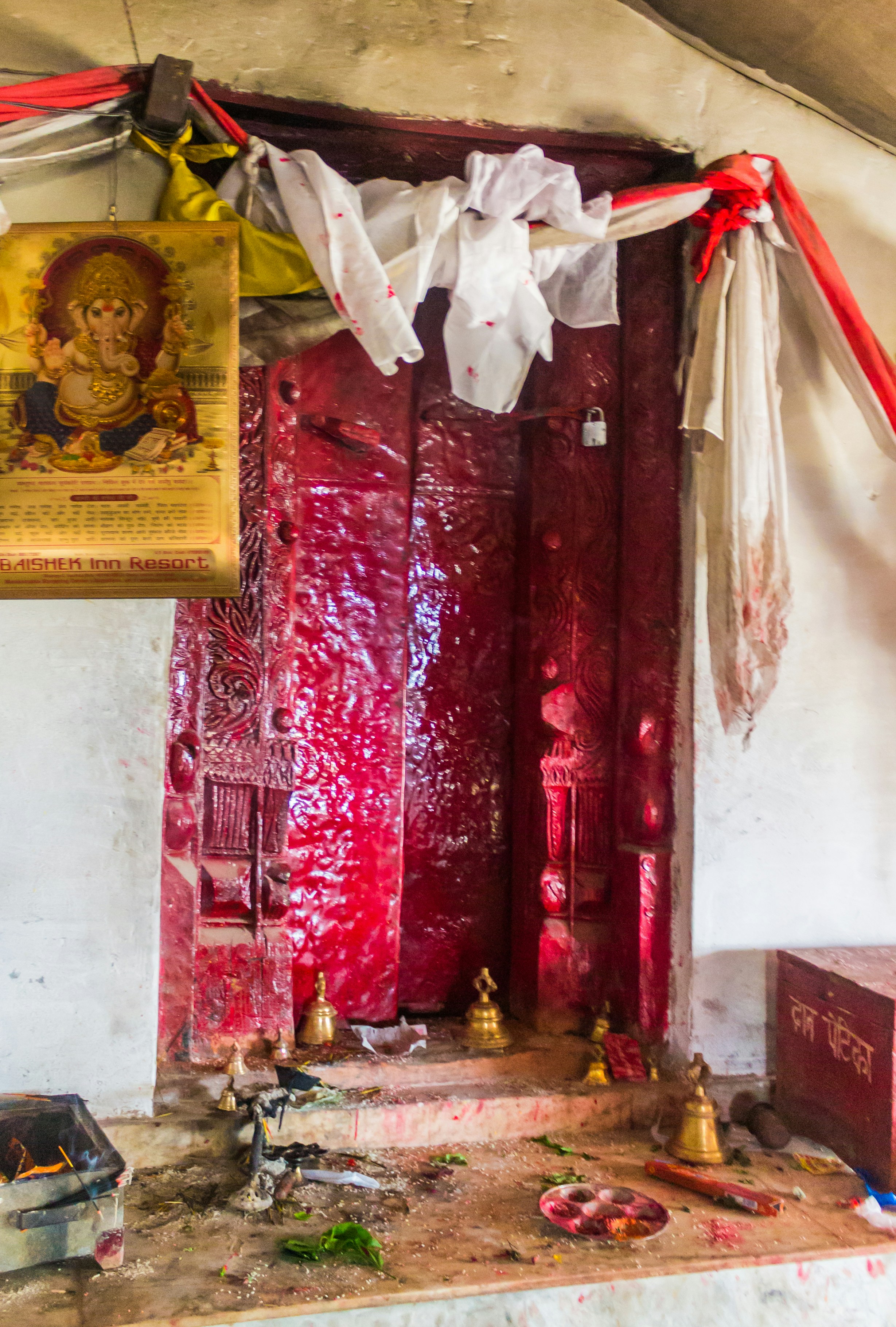 Crimson Shrine Portal Framed by Prayer Cloths and Offering Lamps