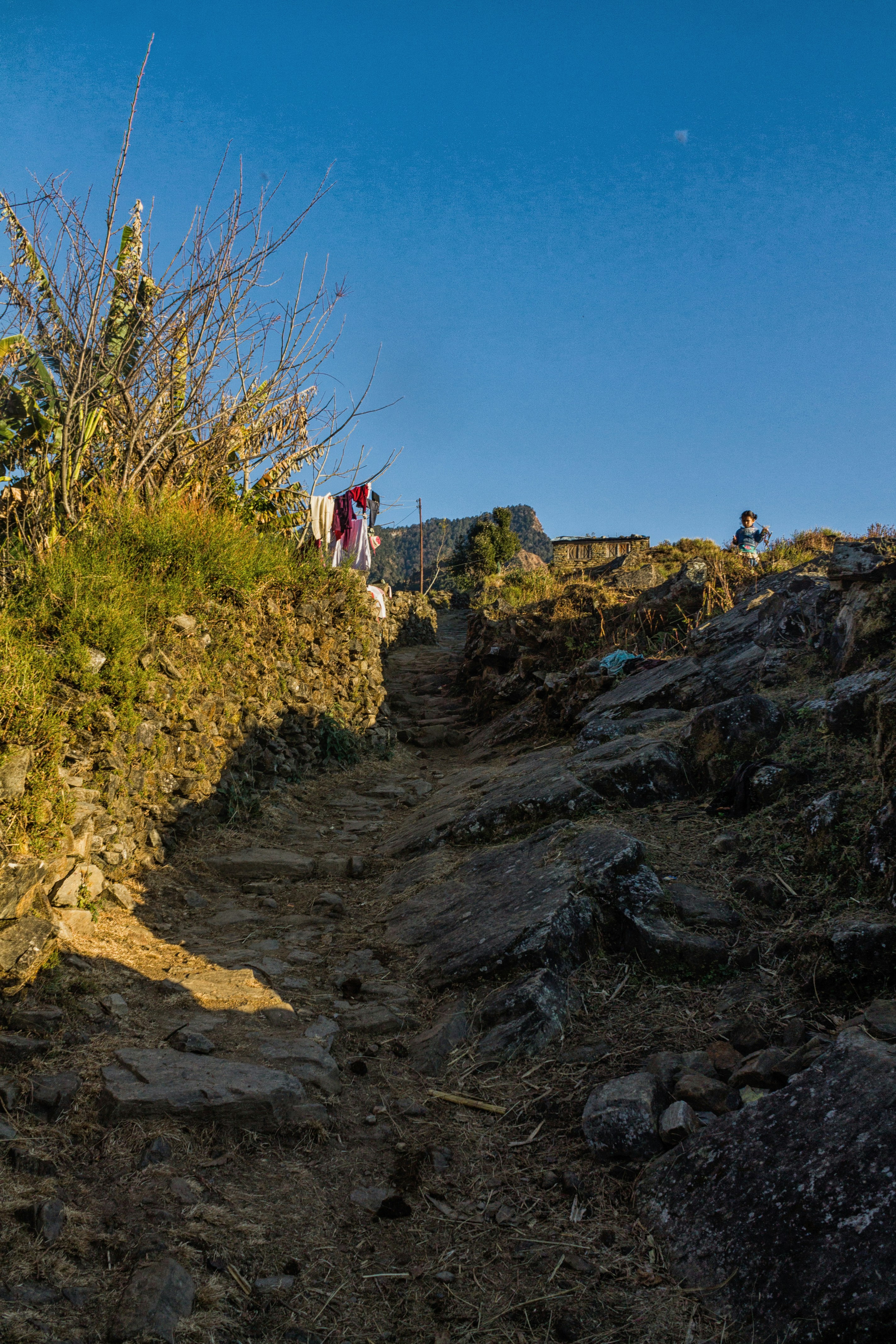 Clifftop Ascent: Laundry Lines, Rugged Steps, and a Watching Figure