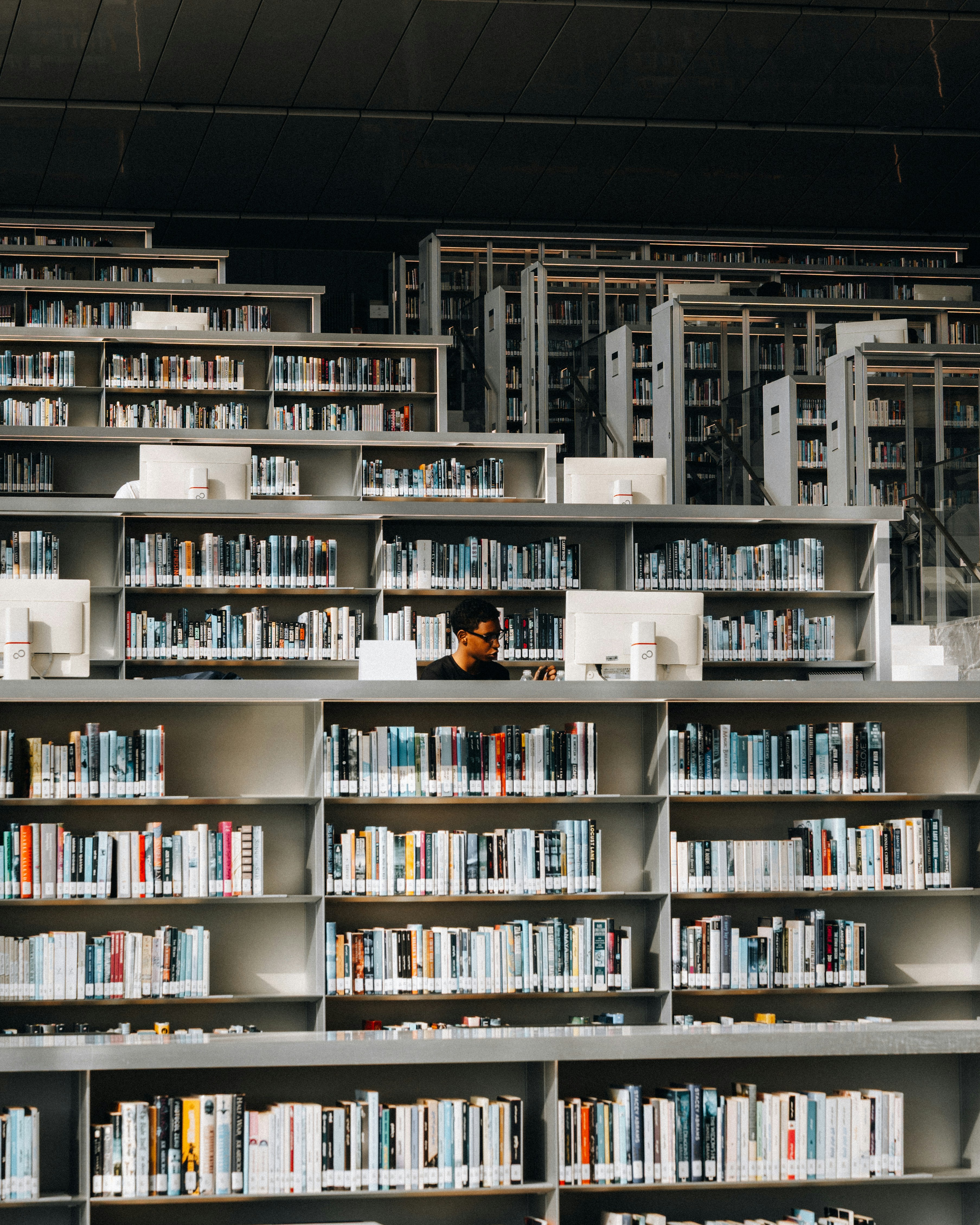 Endless shelves rising toward soft light