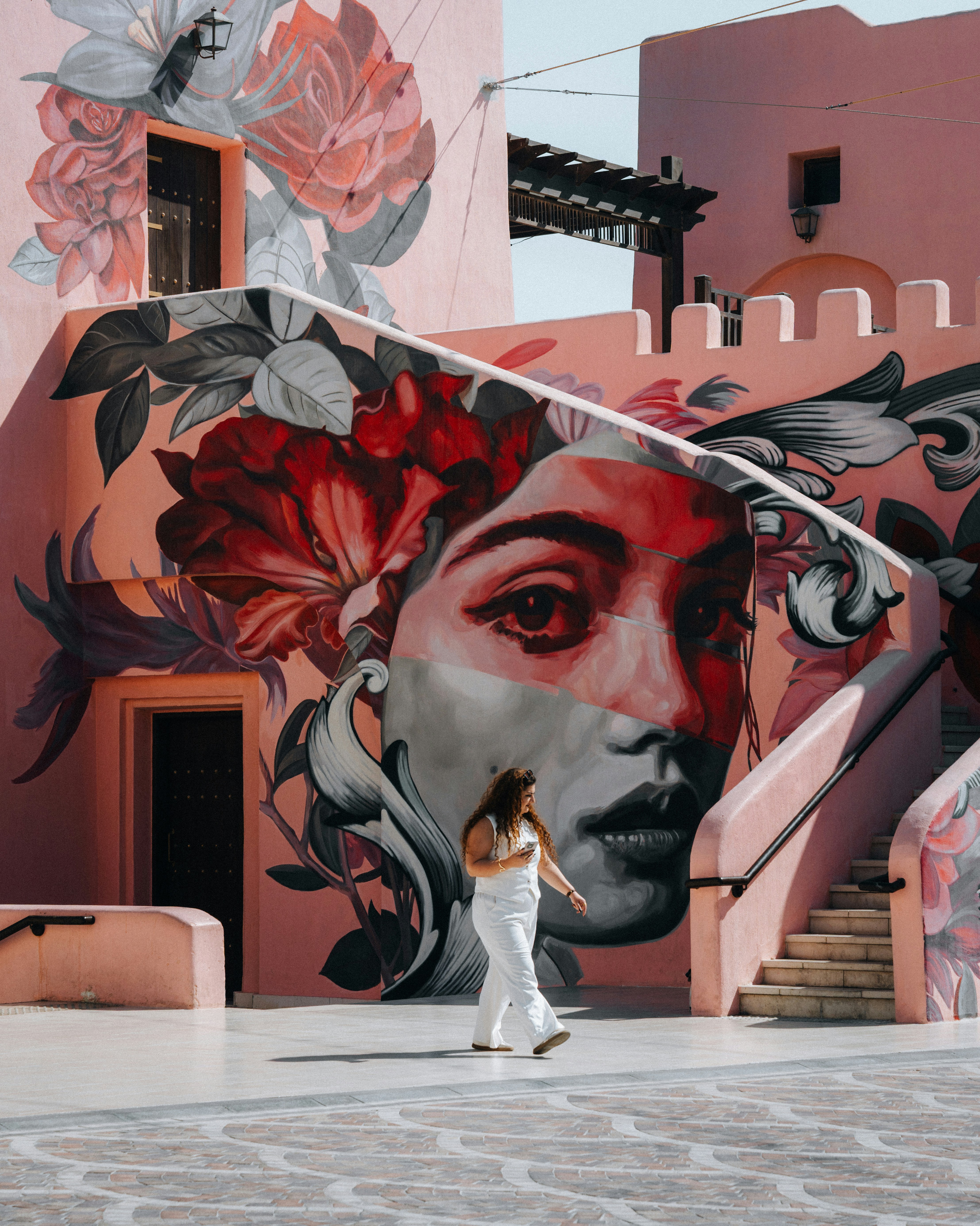 Footsteps Through a Portrait Garden: White Dress Among a Pink Mural World