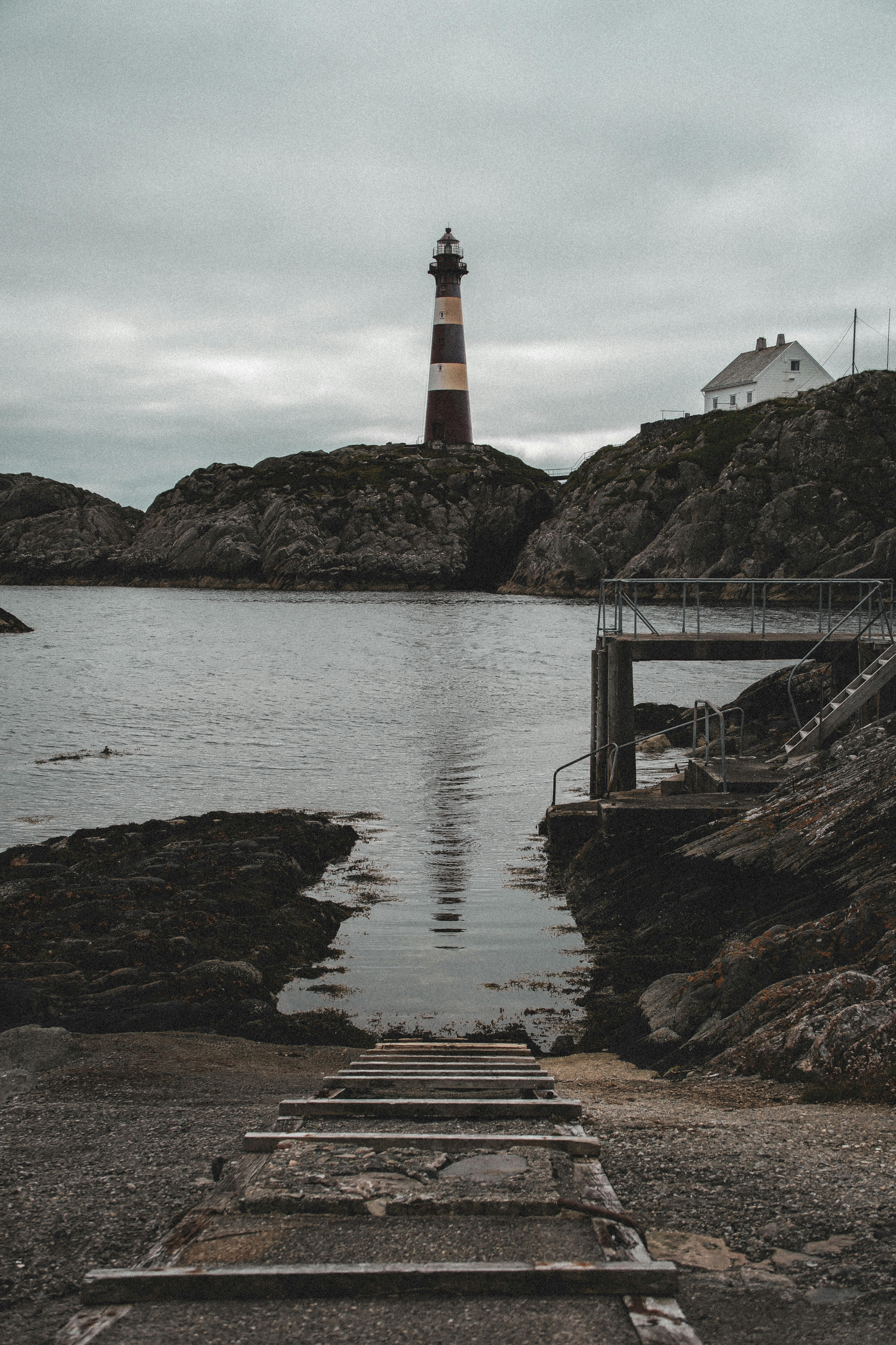Staircase to the Sea: A Granite Promontory Lighthouse Under Moody Skies