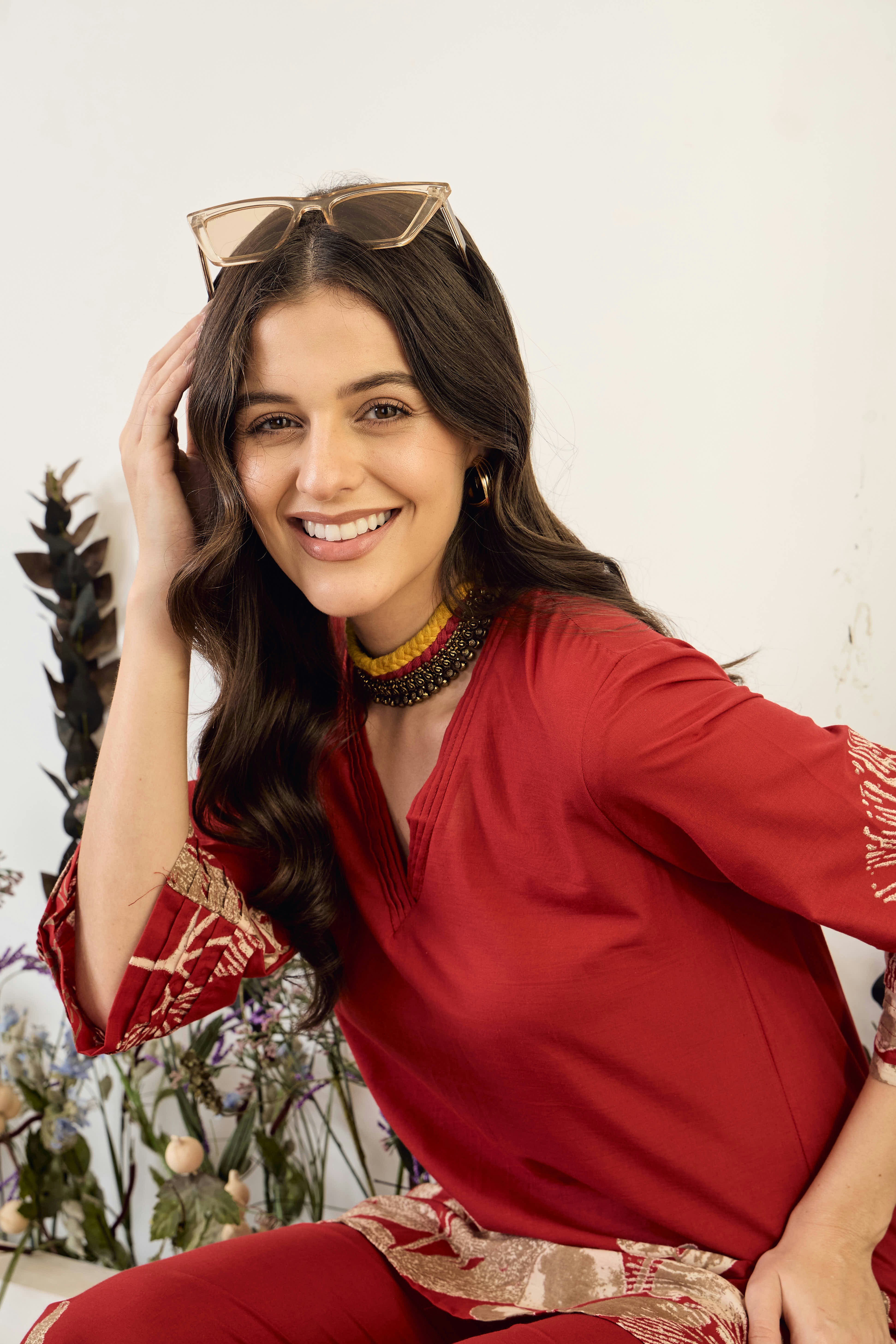 Crimson Portrait: A Warm Studio Moment Amid Quiet Florals