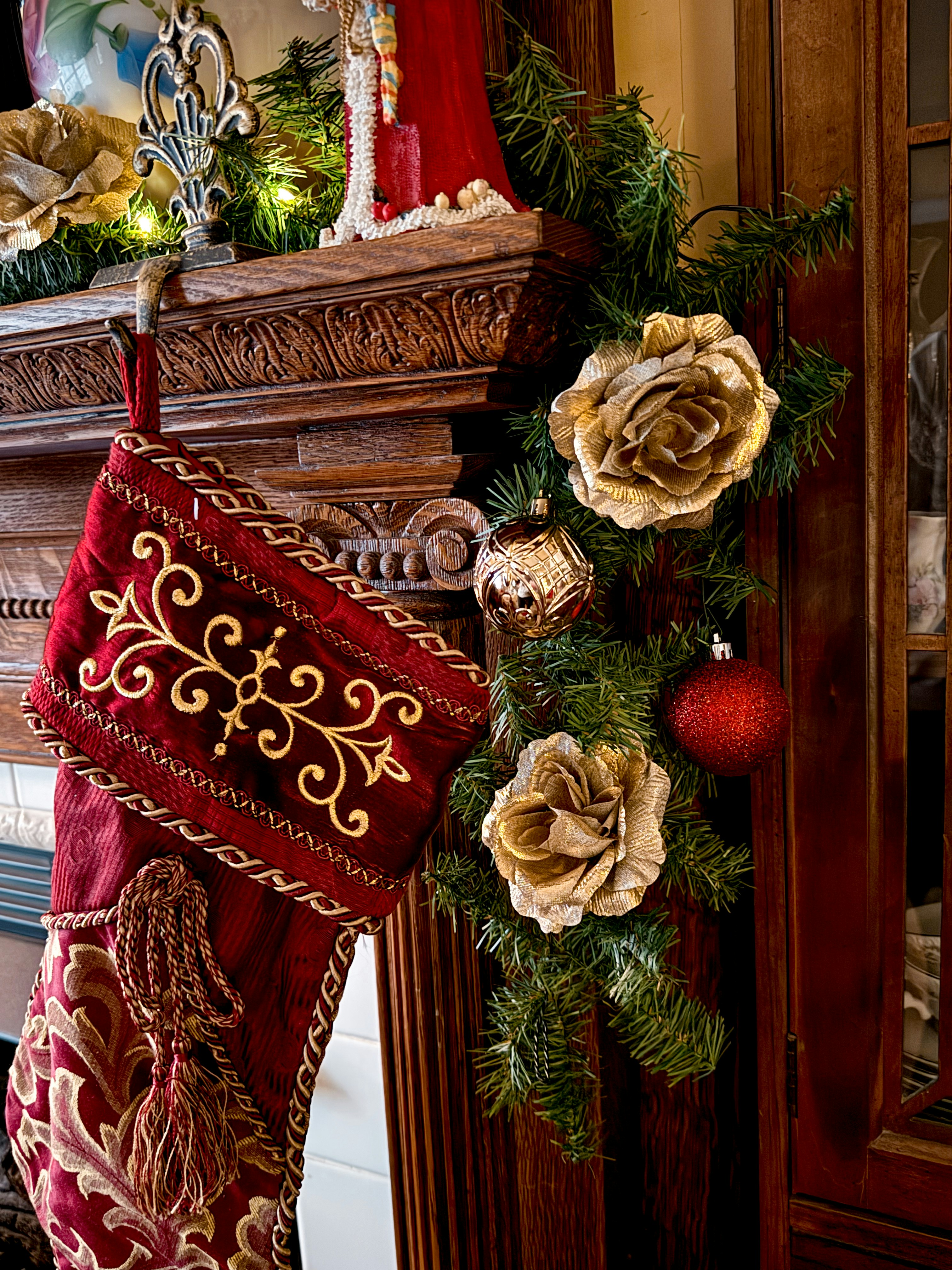 Embroidered Velvet Stocking Framing a Festive Mantel of Greens and Gold