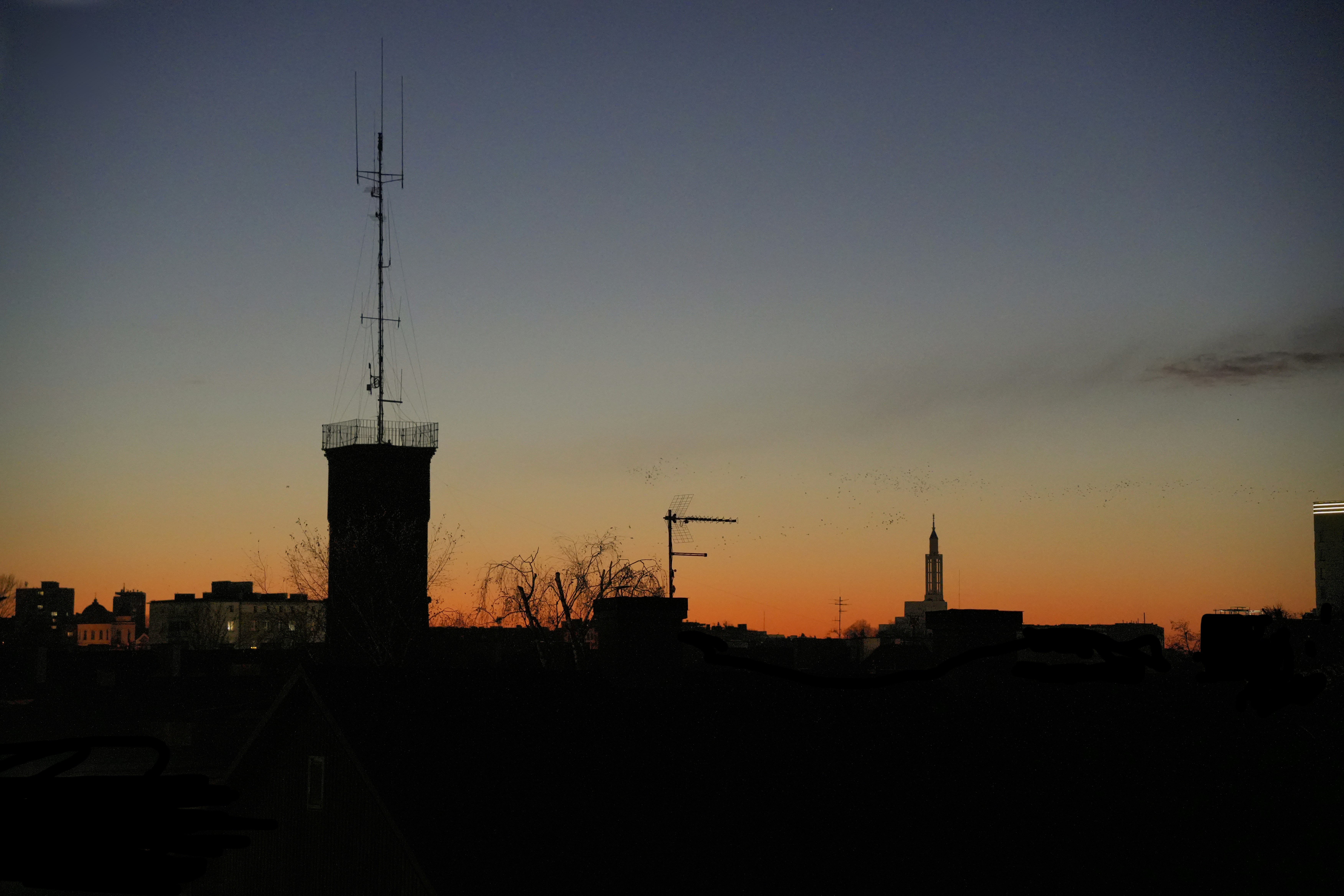 Antenna Sentinel at Dusk: Silhouetted Skyline Against Velvet Twilight