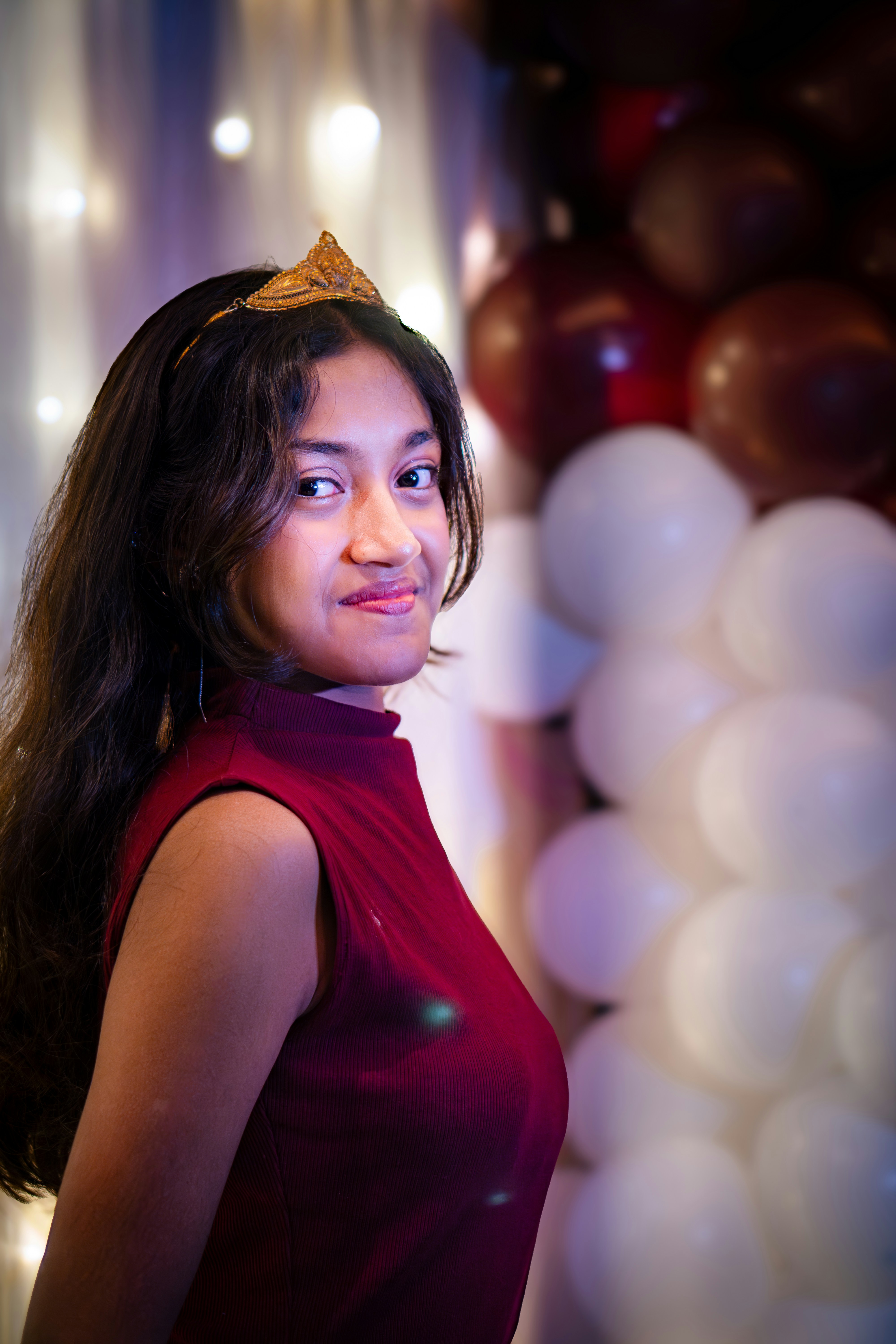Crowned Moment: Portrait of a Birthday Queen Amid Balloon Glow