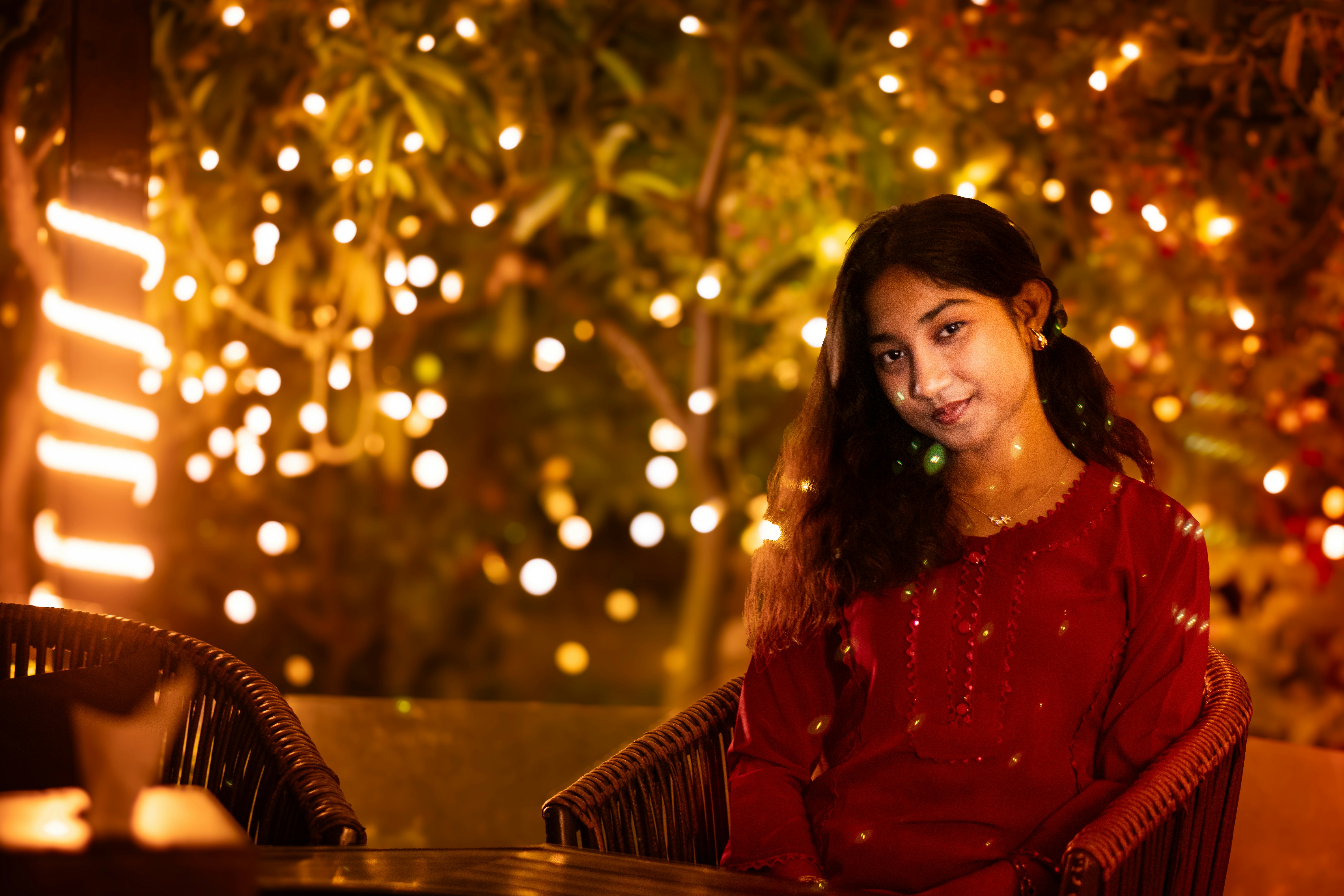 Red in the Glow: Intimate Portrait Amid Fairy Lights