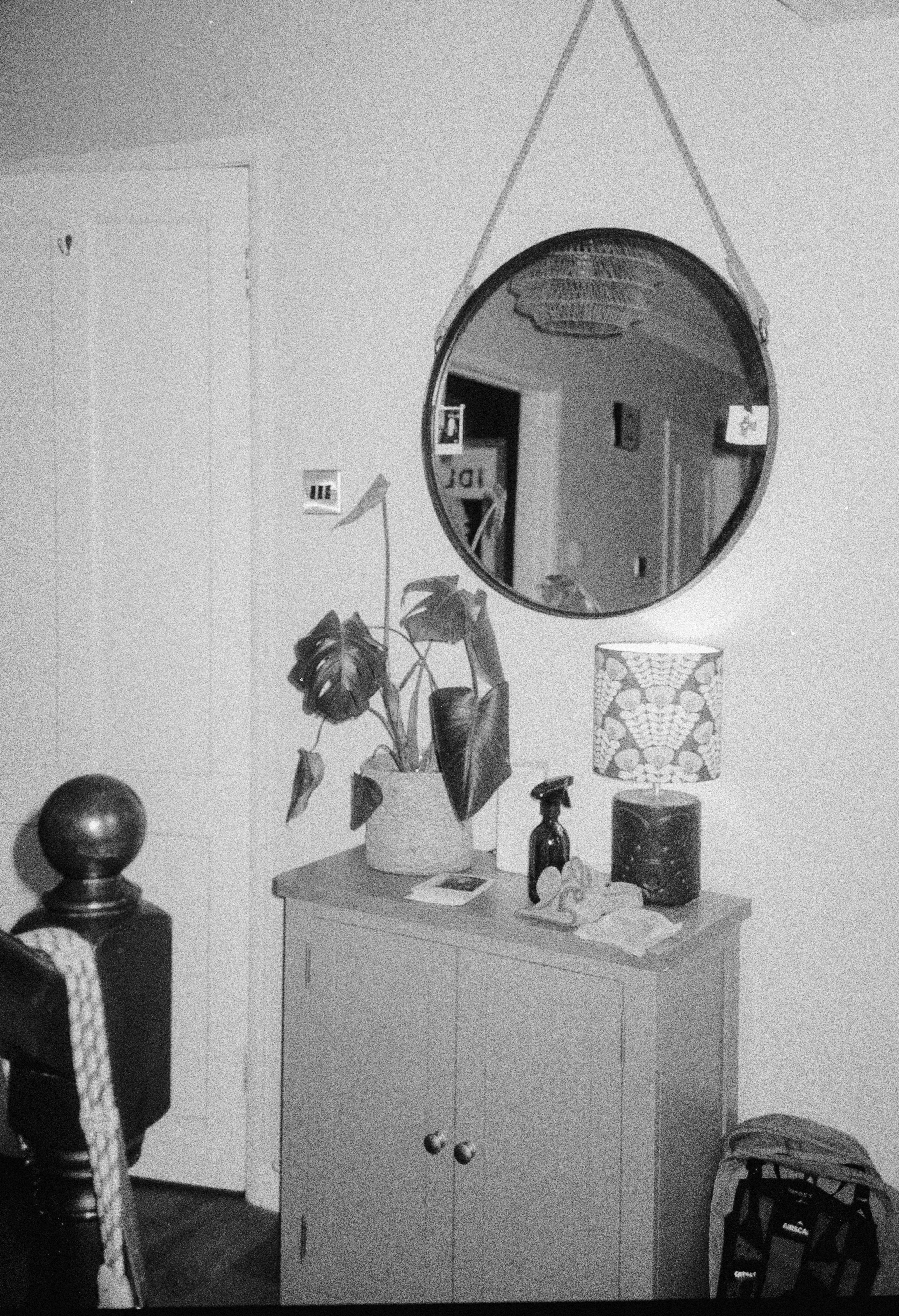Round Mirror Over a Quiet Cabinet: A Black-and-White Corner Study