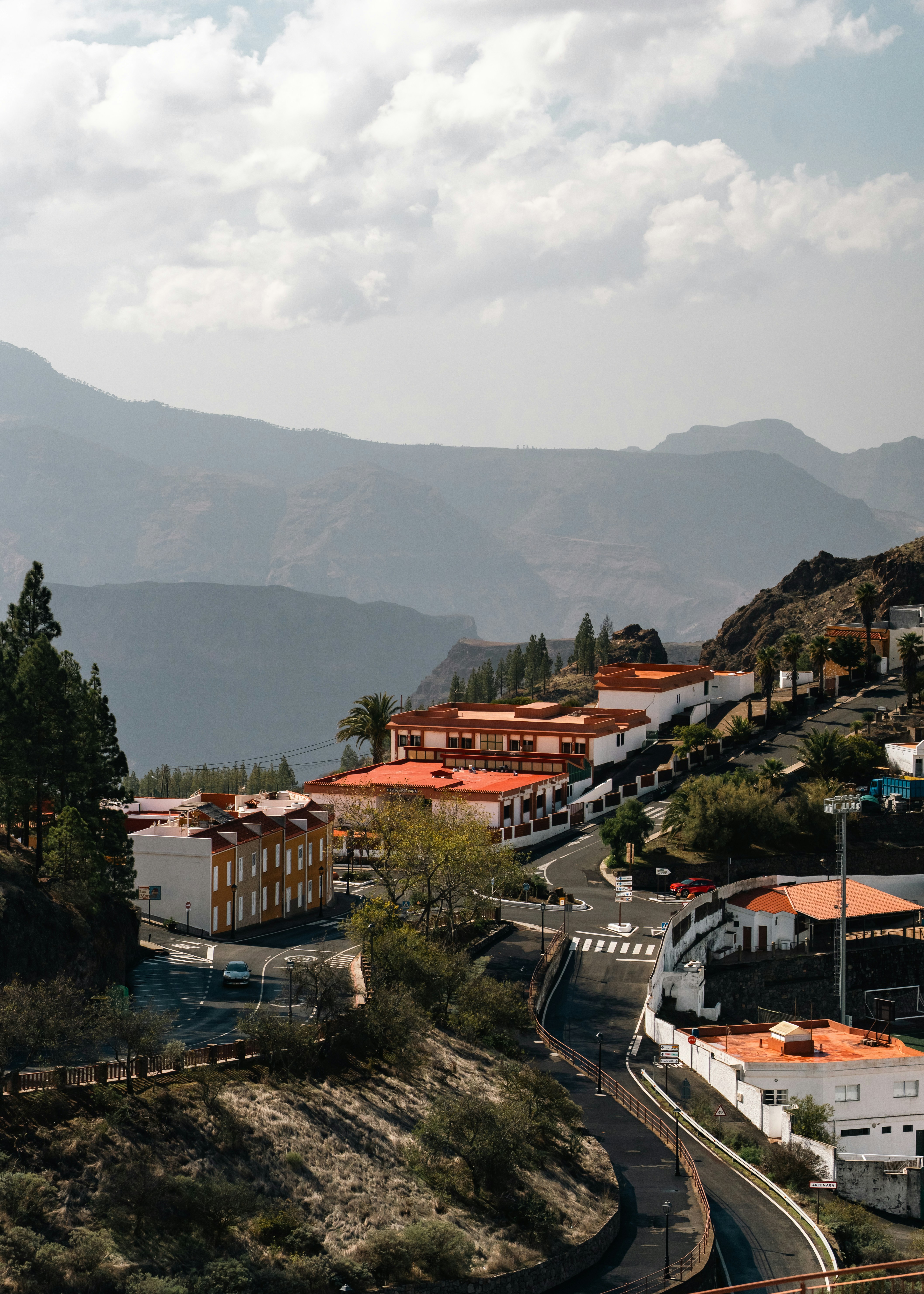 Terraced Village of Orange Roofs Along a Serpentine Mountain Road