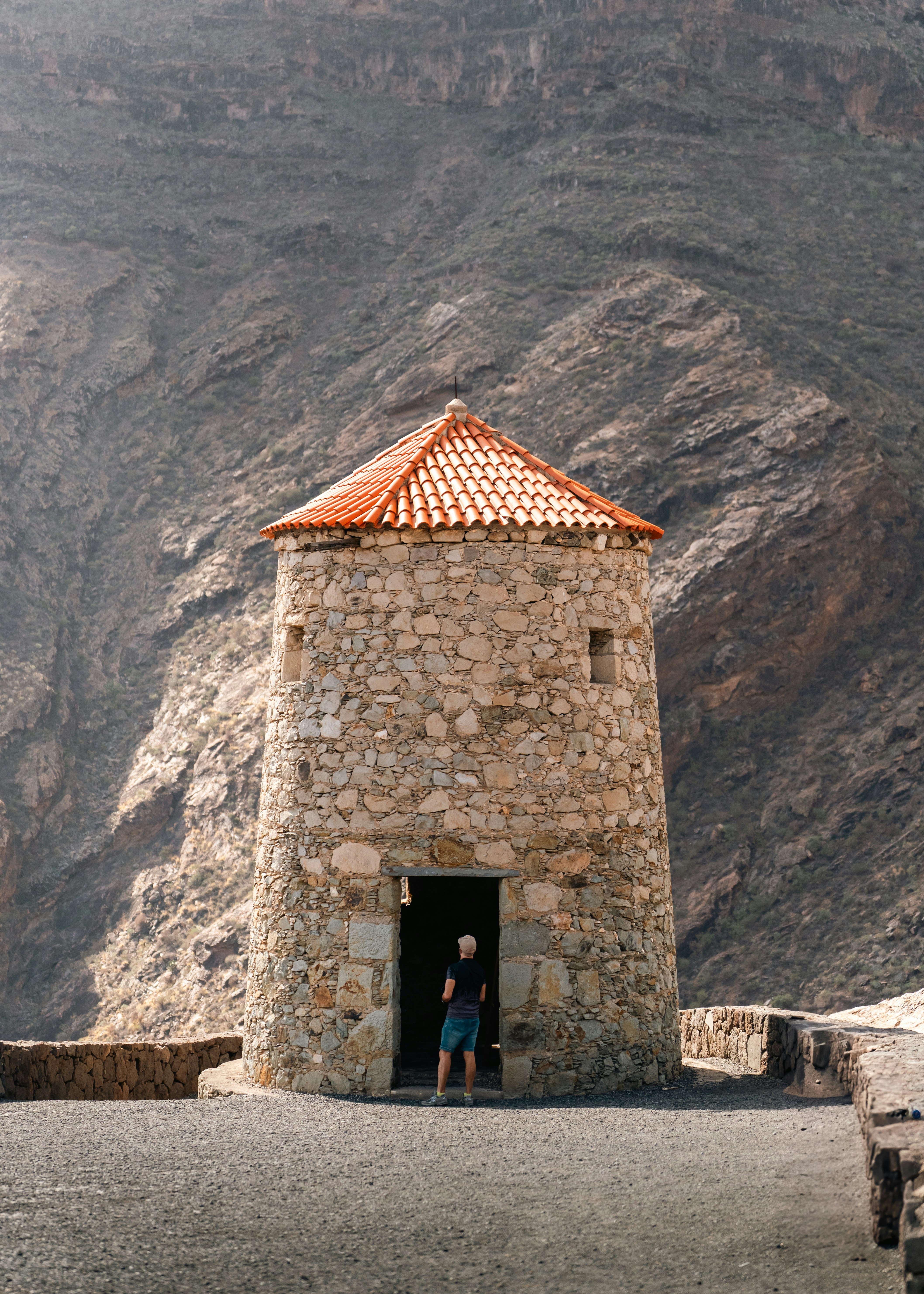 Terracotta Turret at the Cliff's Edge: A Stone Sentinel and Its Visitor
