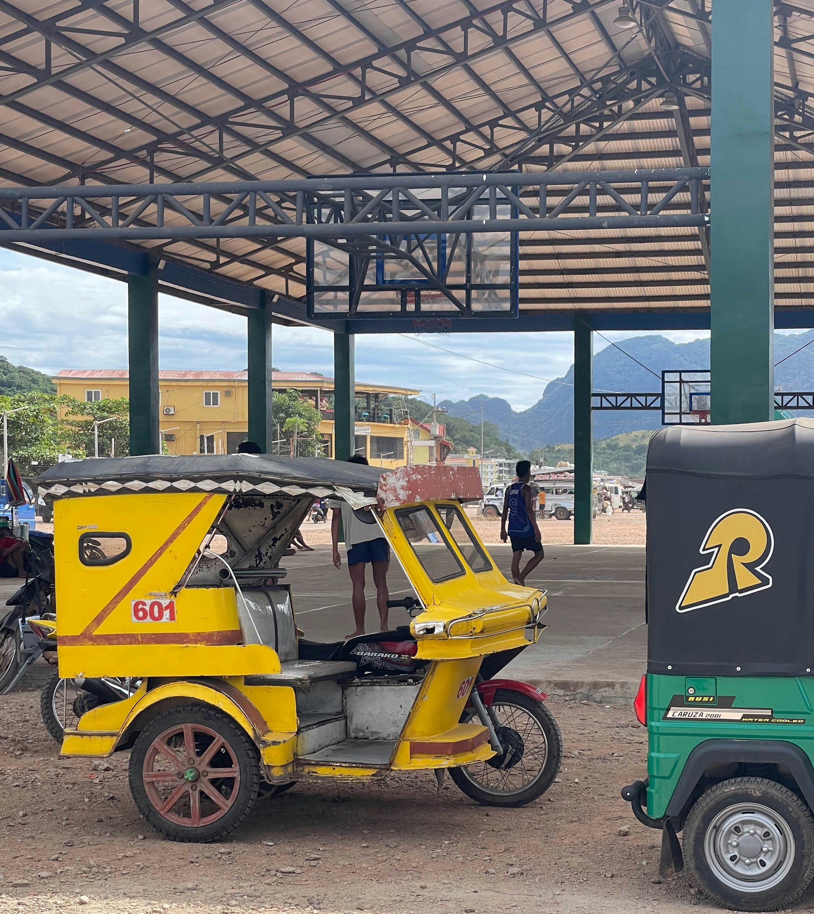 Yellow Tuk-Tuk Under the Canopy: Street Scene by the Distant Hills