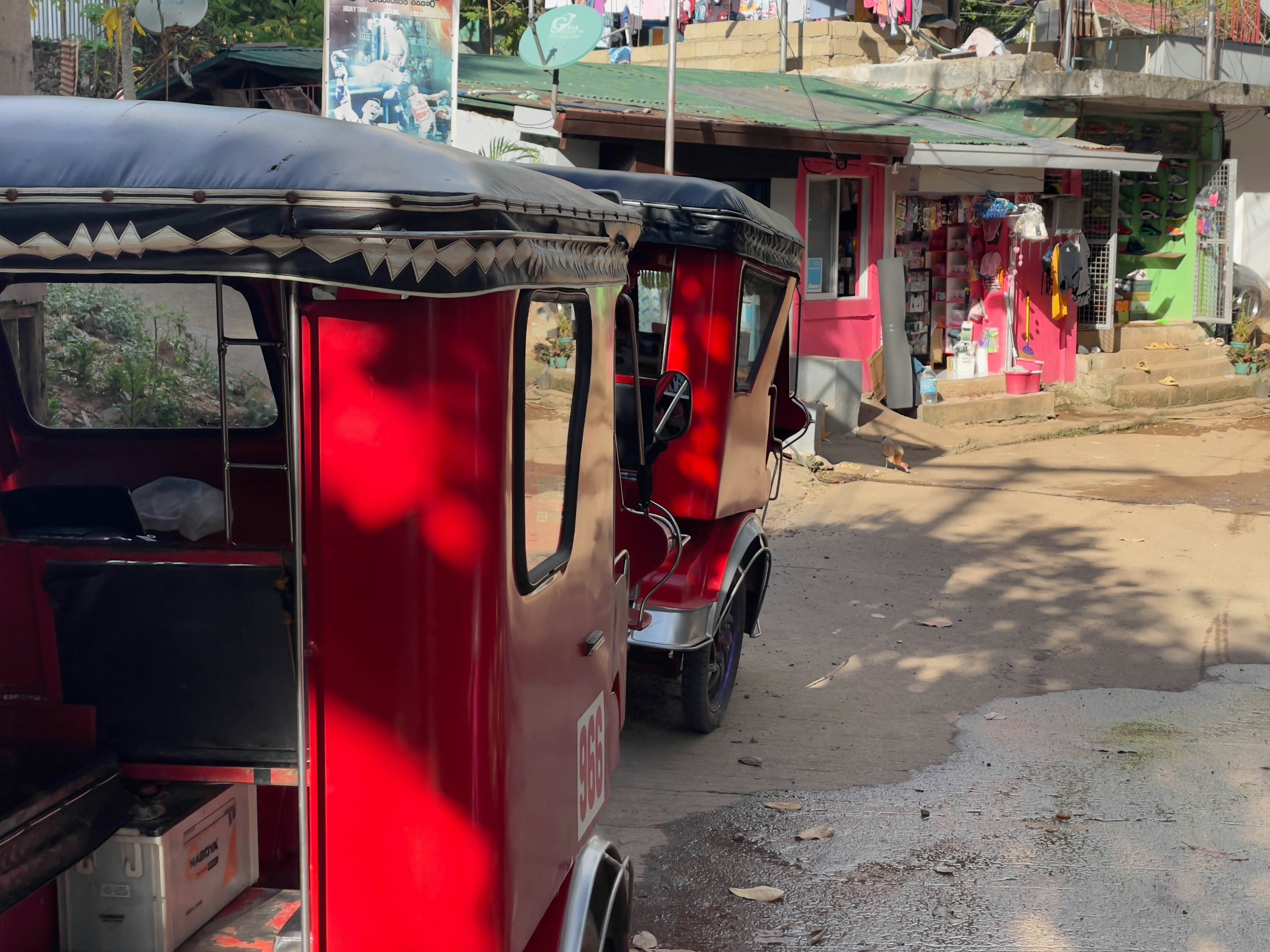 Crimson Tuk-Tuk at the Edge of a Bustling Market Lane