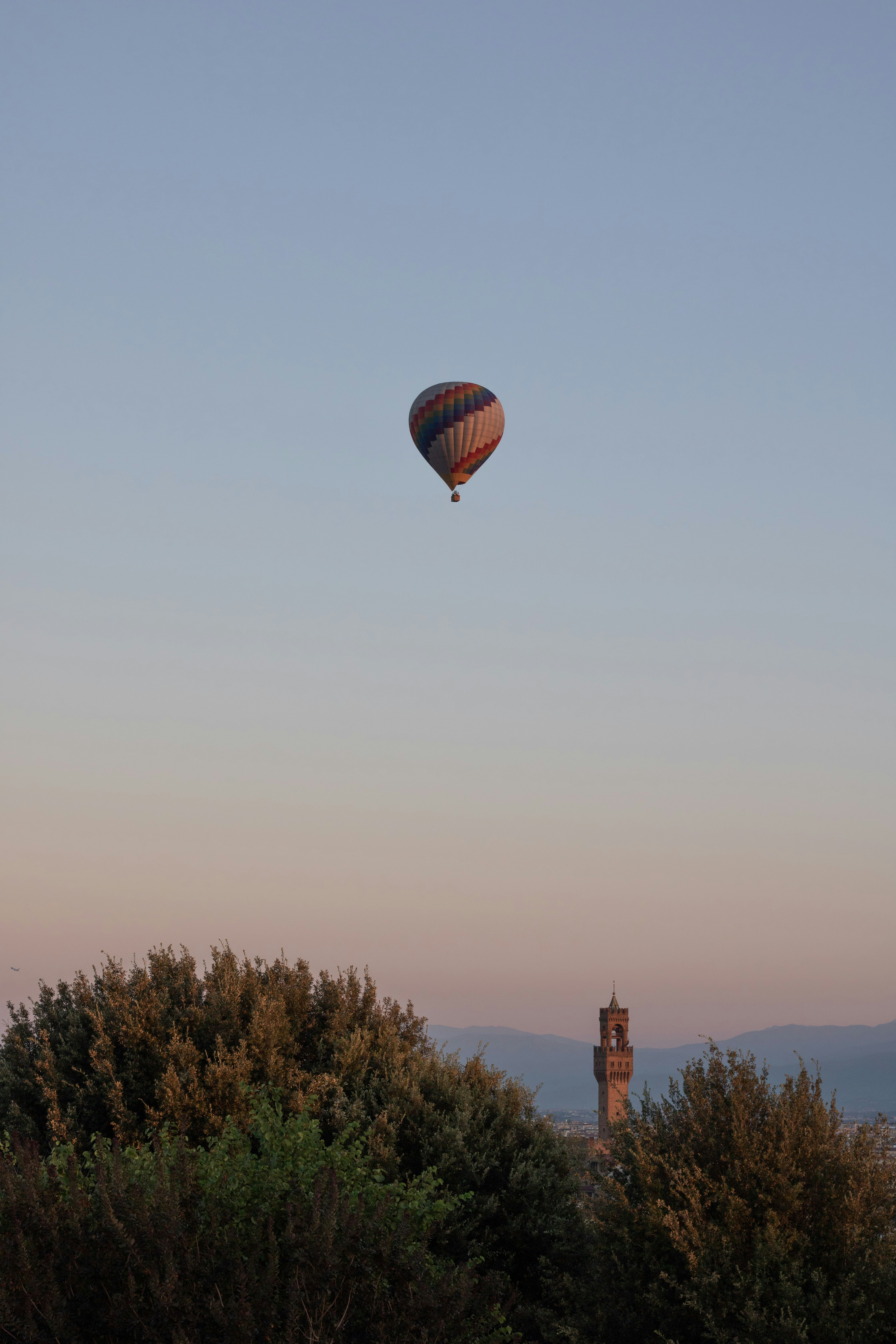 Dusk Drift: Hot Air Balloon Over a Distant Clock Tower